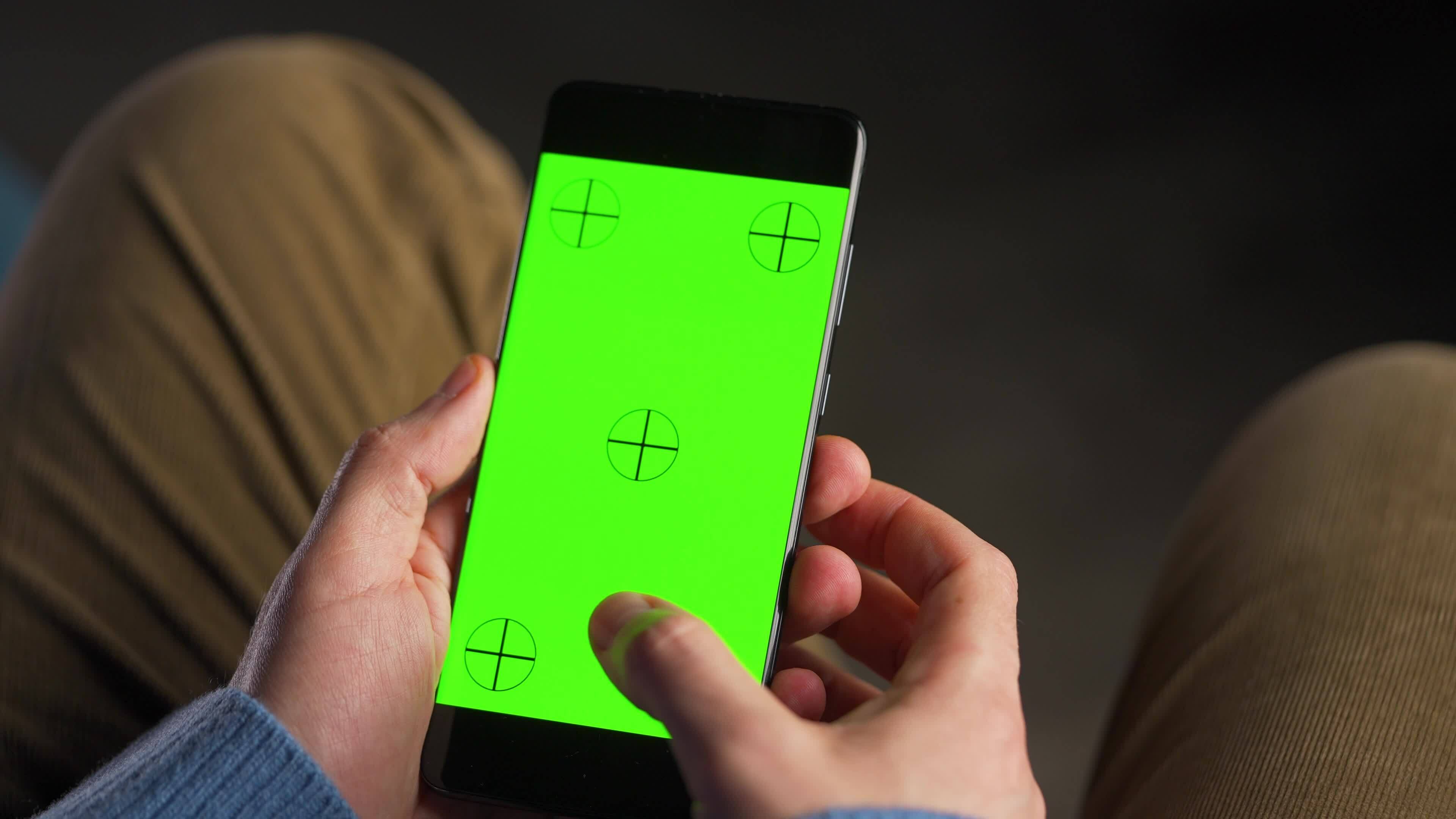 Man using smartphone with green mock-up screen in vertical mode and drinking coffee. Man ...