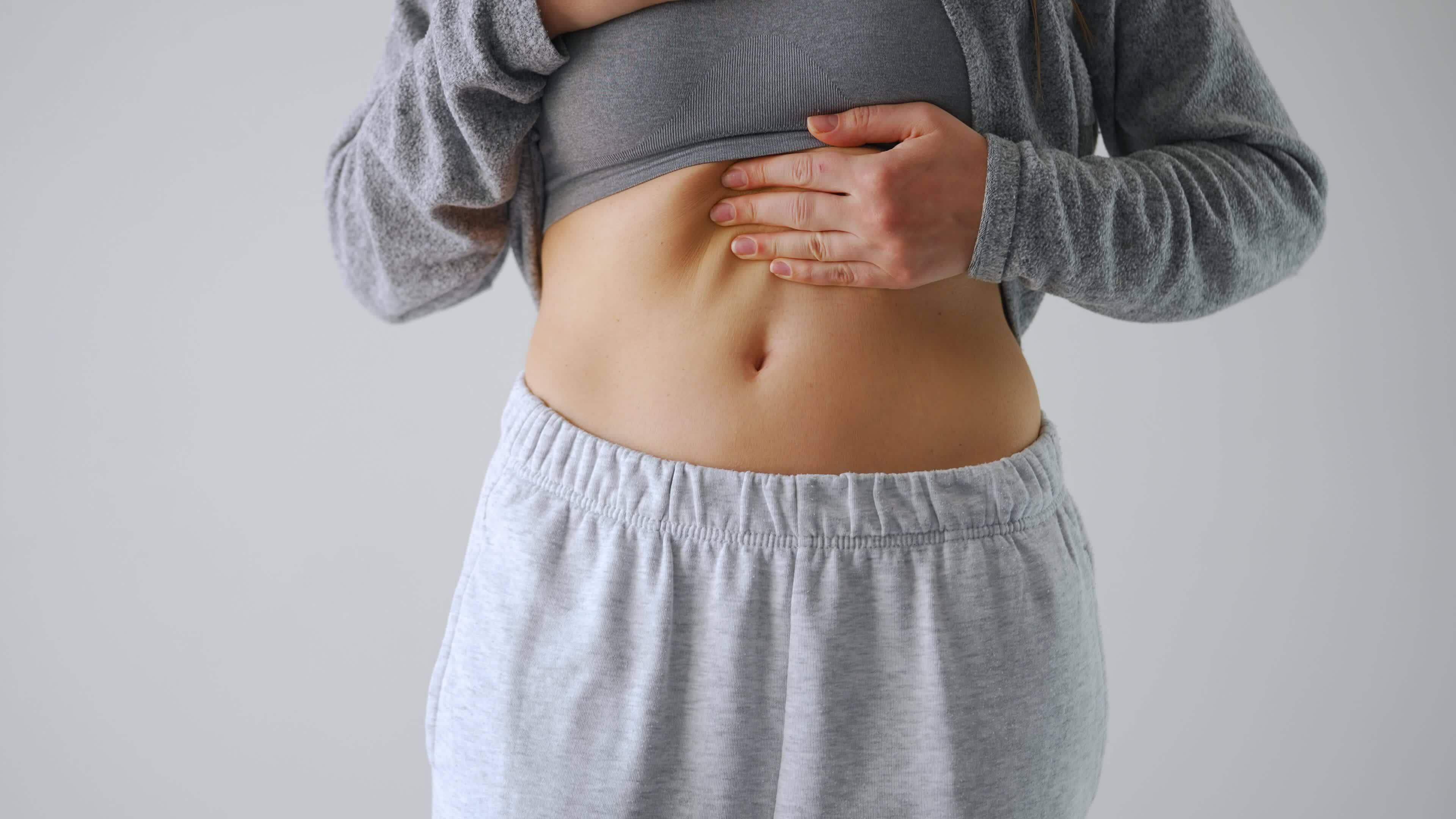 Woman Compressing The Skin On Her Stomach Checking For Cellulite And
