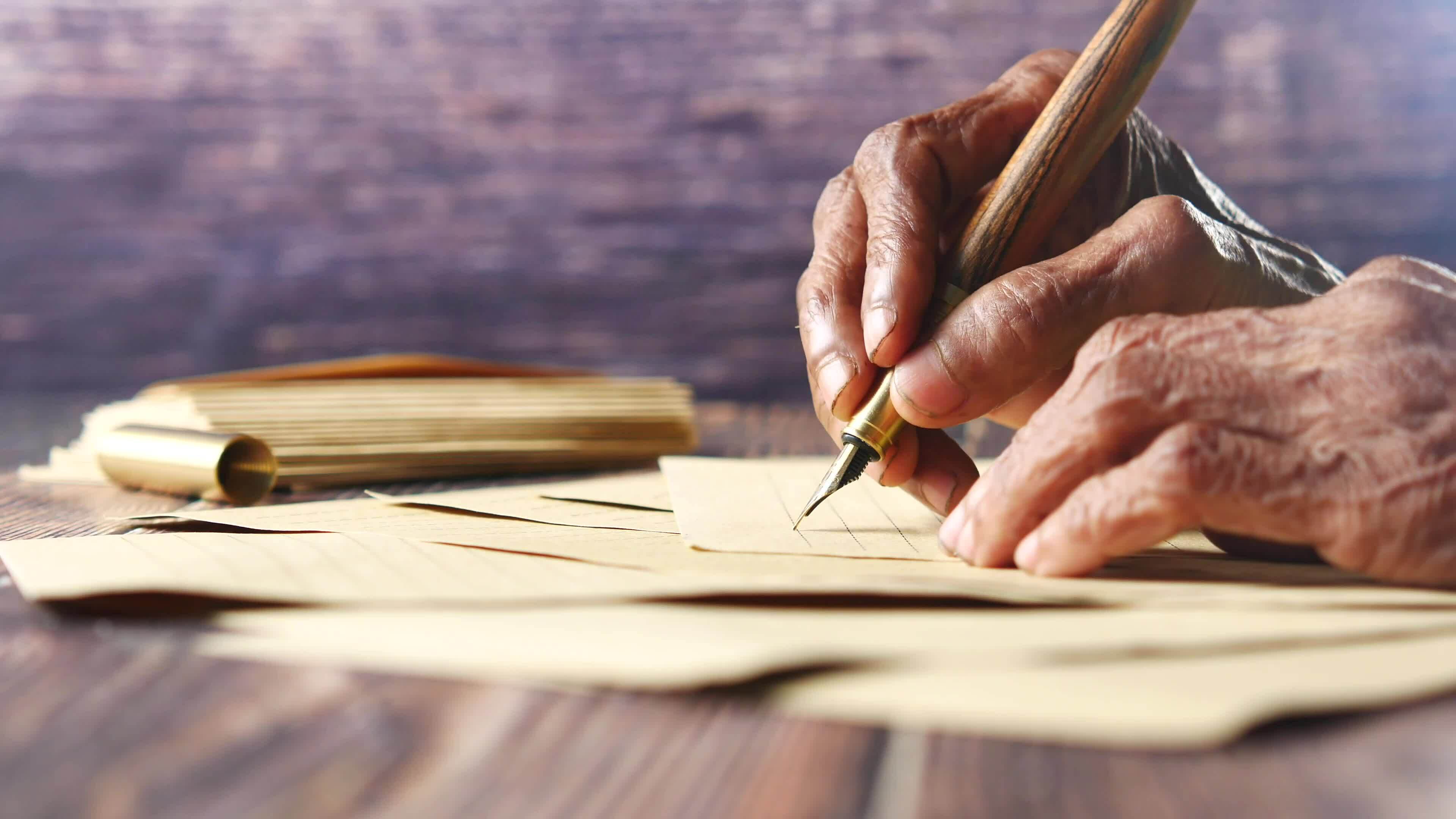 an old man writing on paper with a pen 26456227 Stock Video at Vecteezy