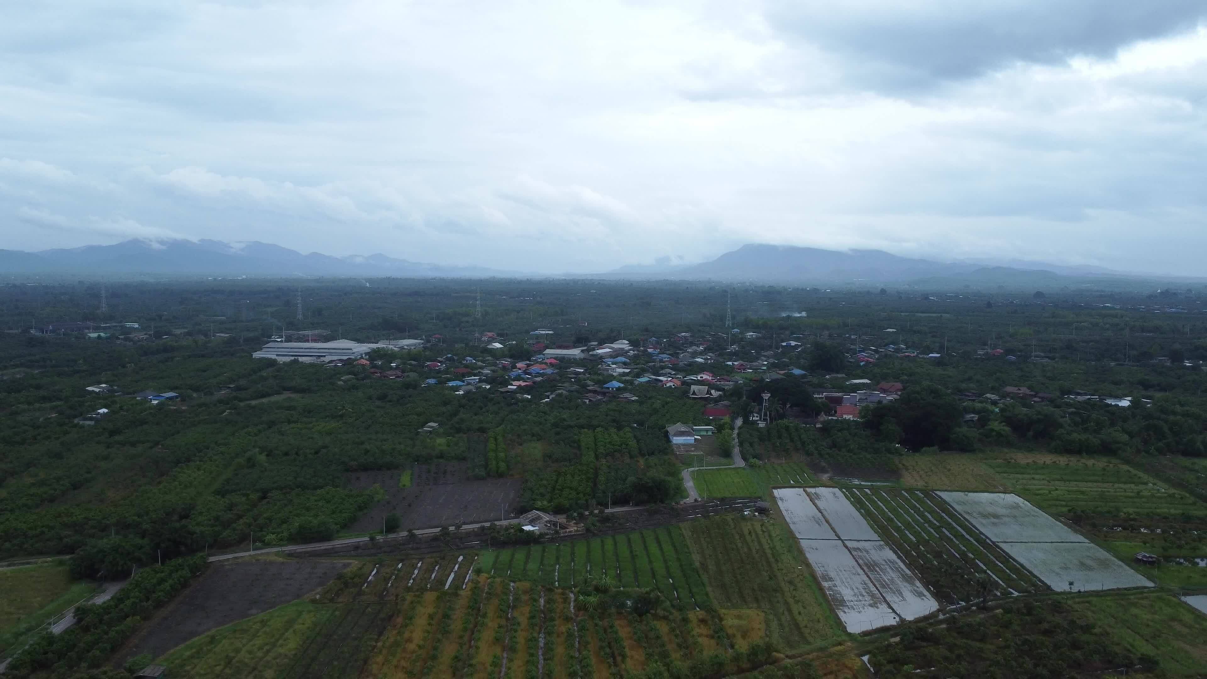 vue aérienne d'un agriculteur dans un tracteur rouge préparant la terre pour la plantation de ...