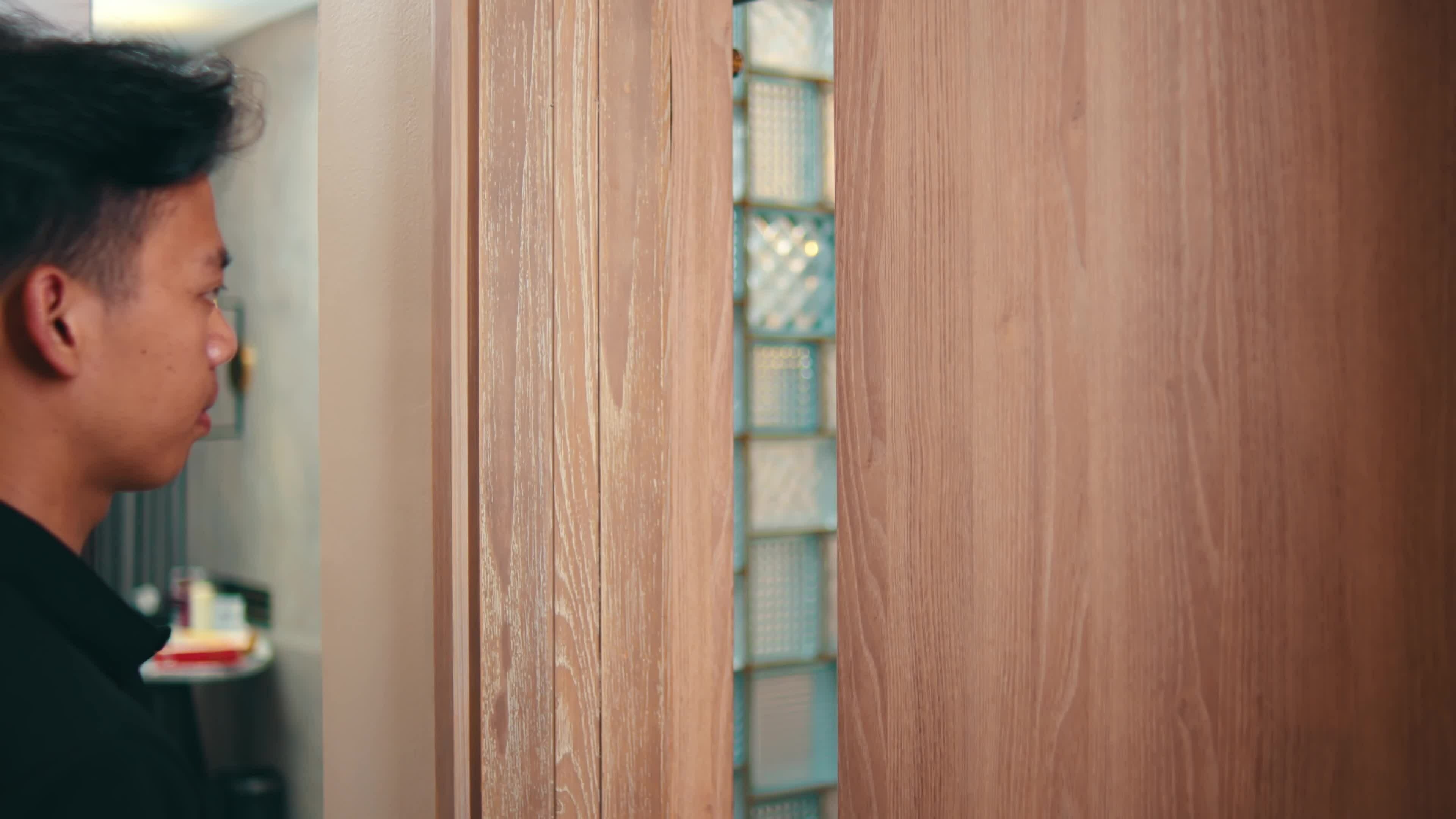 an Asian man is spying on his girlfriend while in the bathroom of a hotel room 28261531 Stock ...