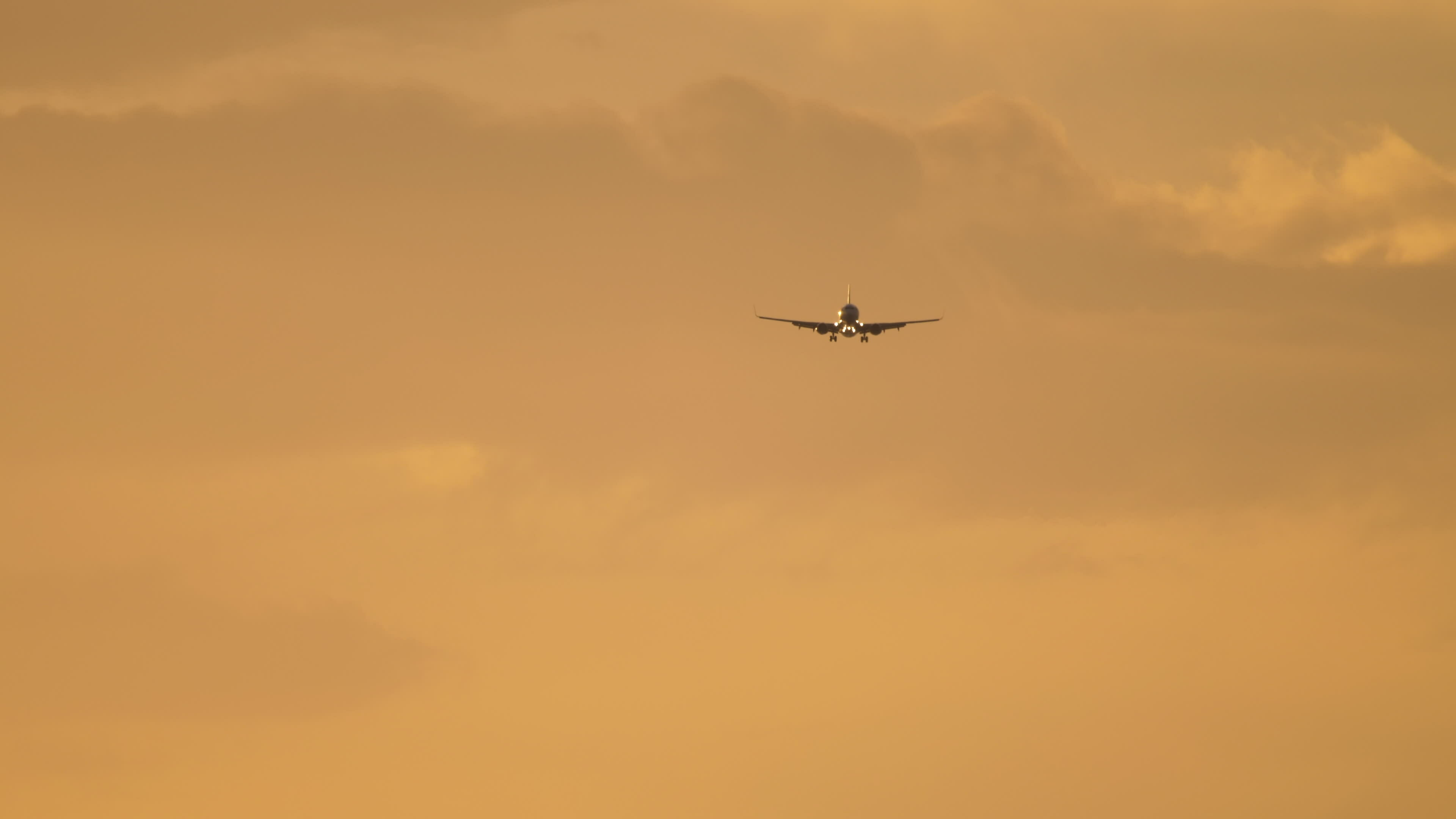 Jet Plane Approaching To Land At Bright Sunset Sky Unrecognizable