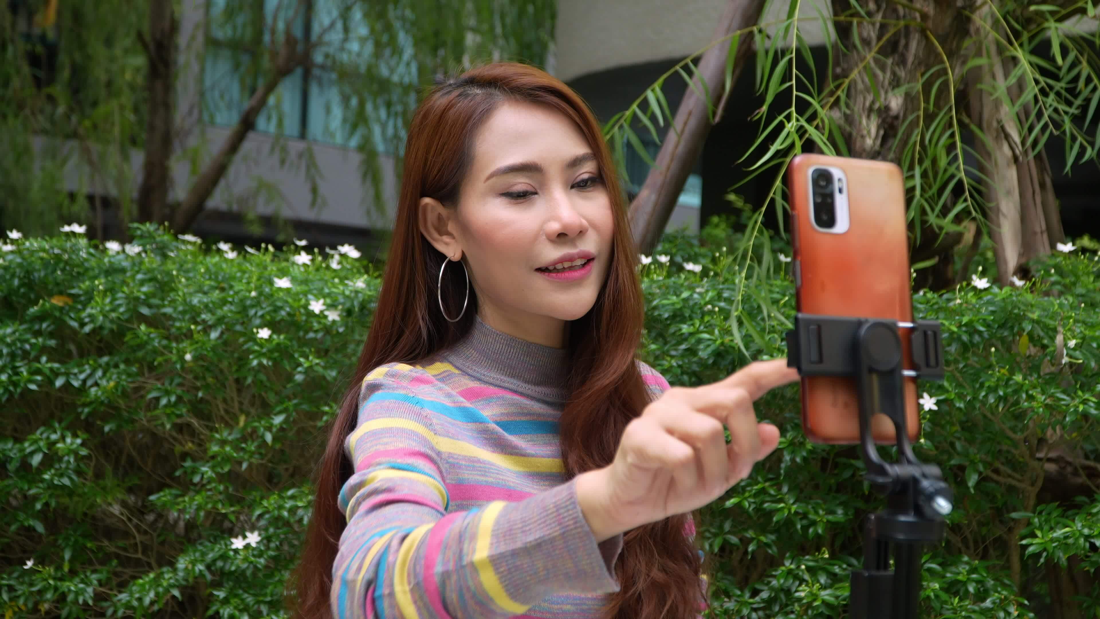 Beautiful Asian woman female blogger use smartphone for broadcasts live on social networks ...