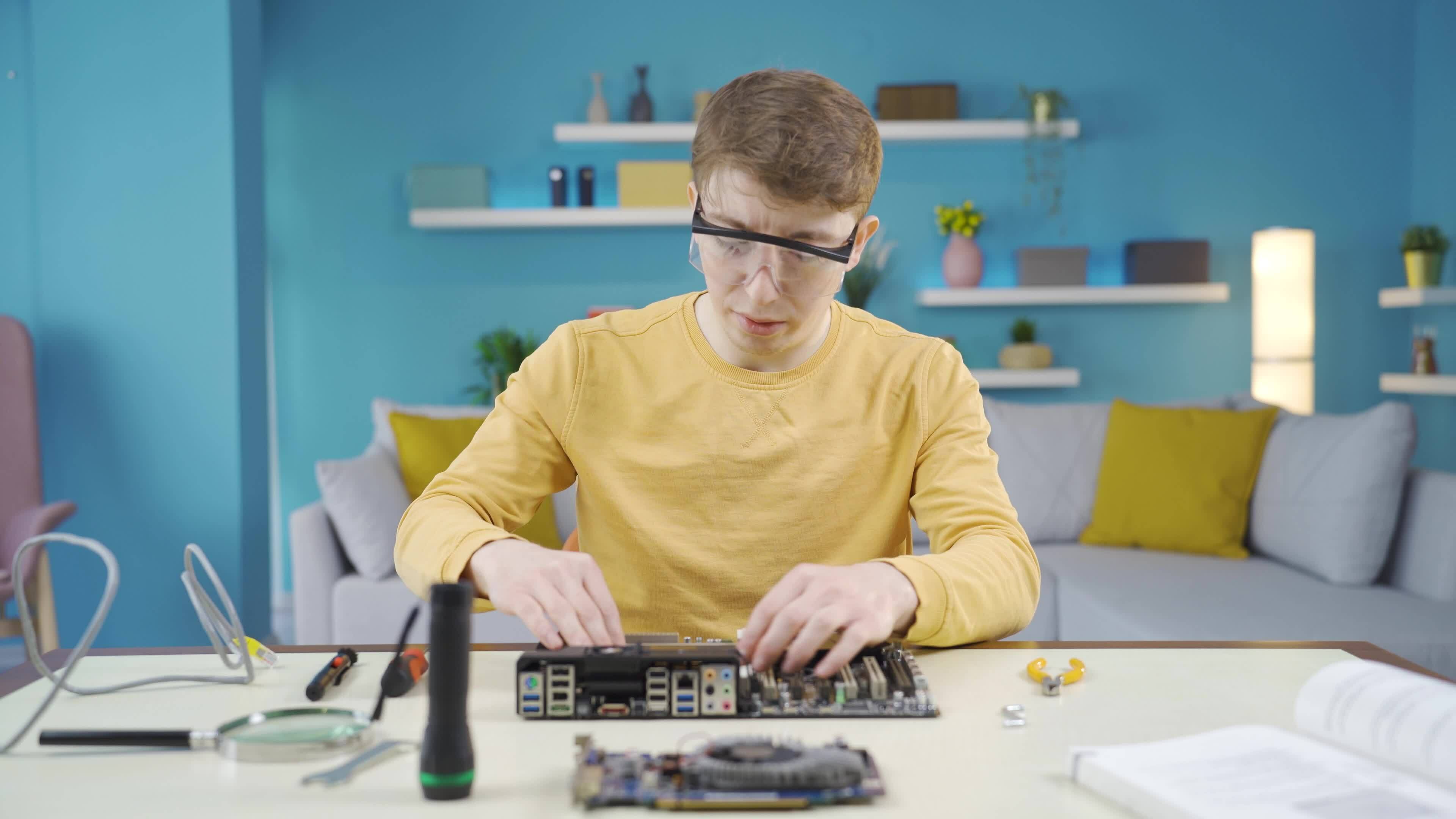 Teenager trying to solve electronics. 33033723 Stock Video at Vecteezy
