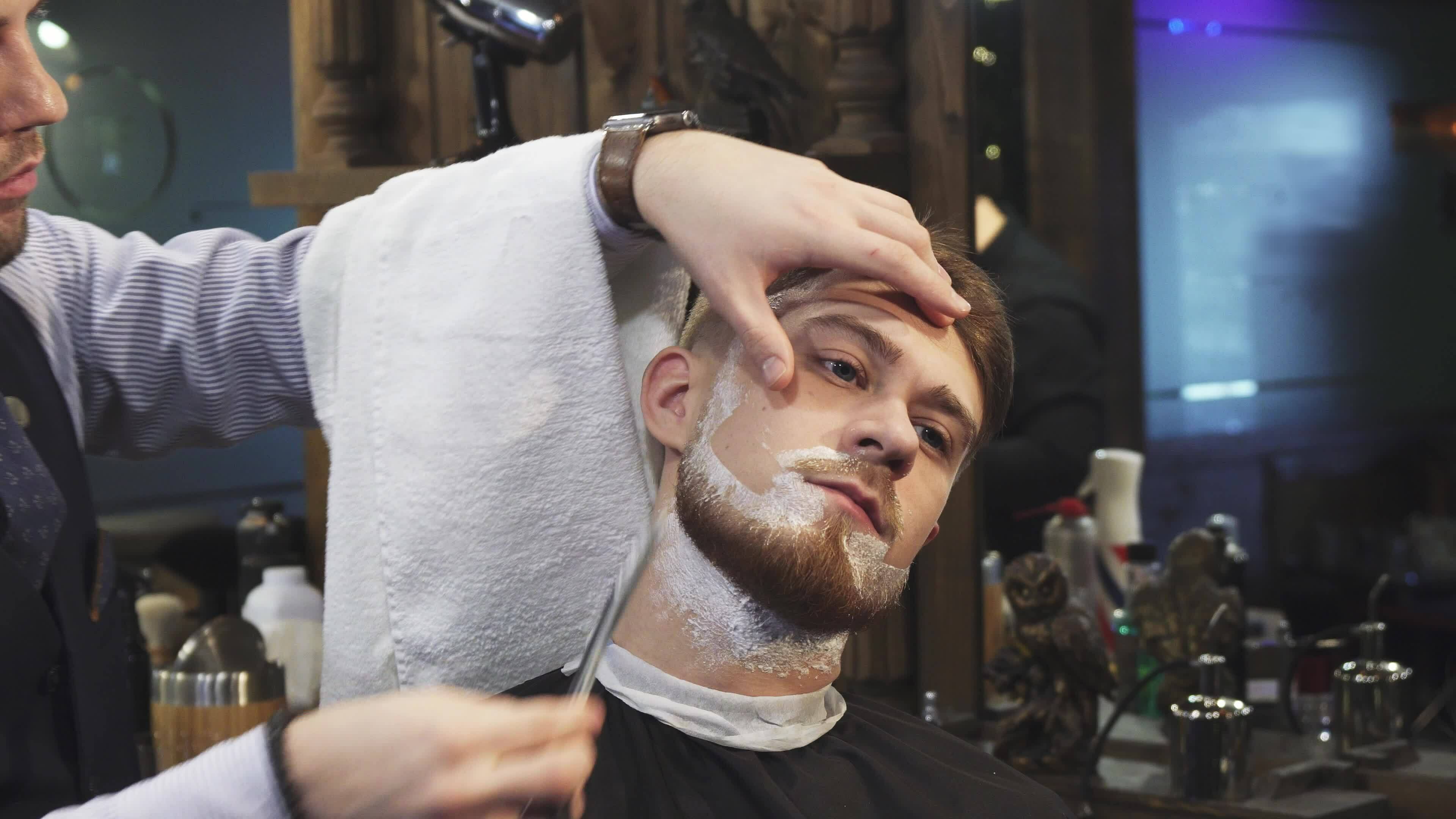 Handsome Young Man Getting His Beard Shaved At The Barbershop 33299848