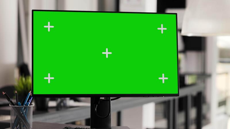 Empty Workstation With Computer Running Greenscreen On Monitor Showing