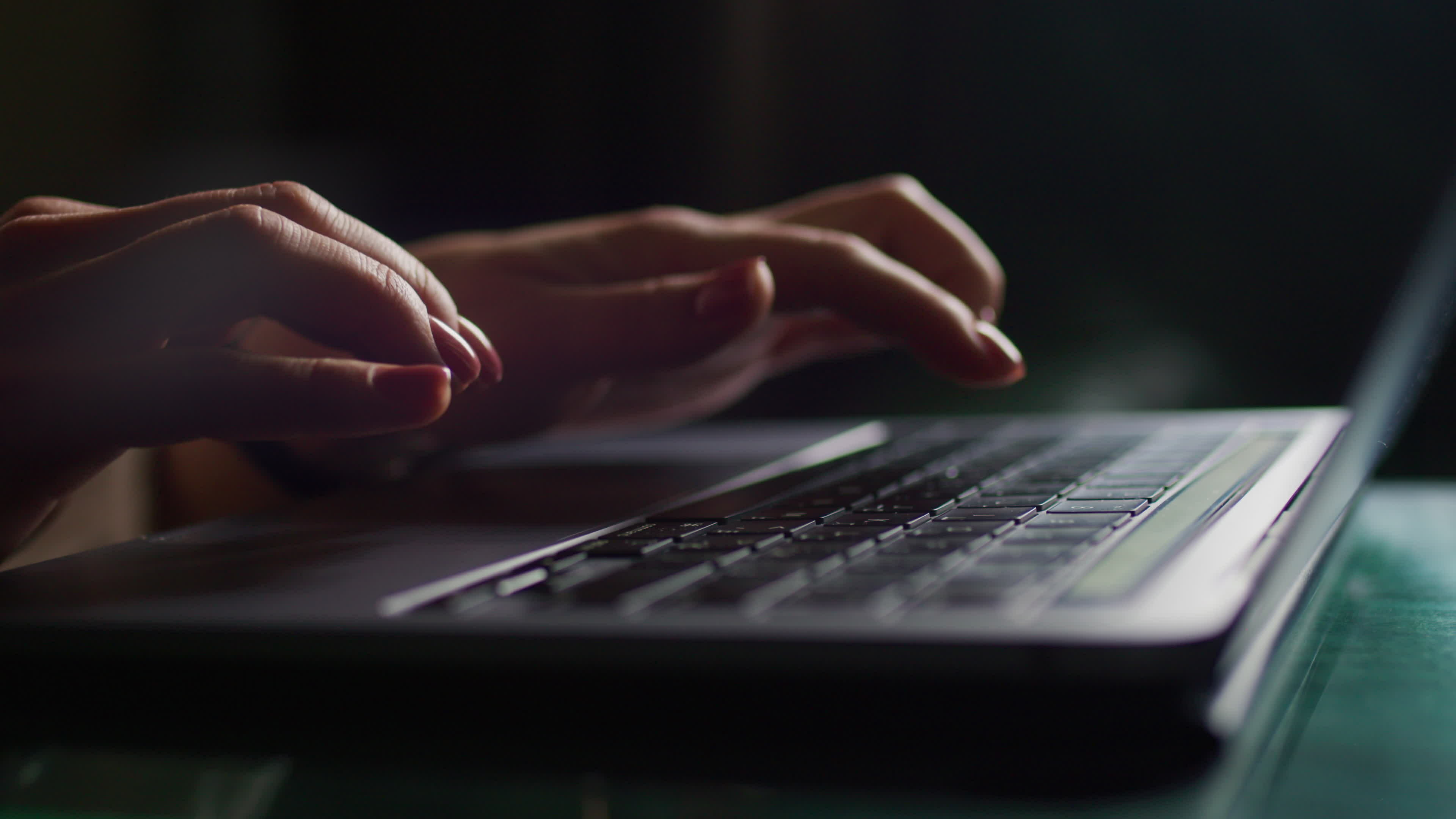 Female hands write text messages on a laptop keyboard close-up. Busy business woman emailing a ...