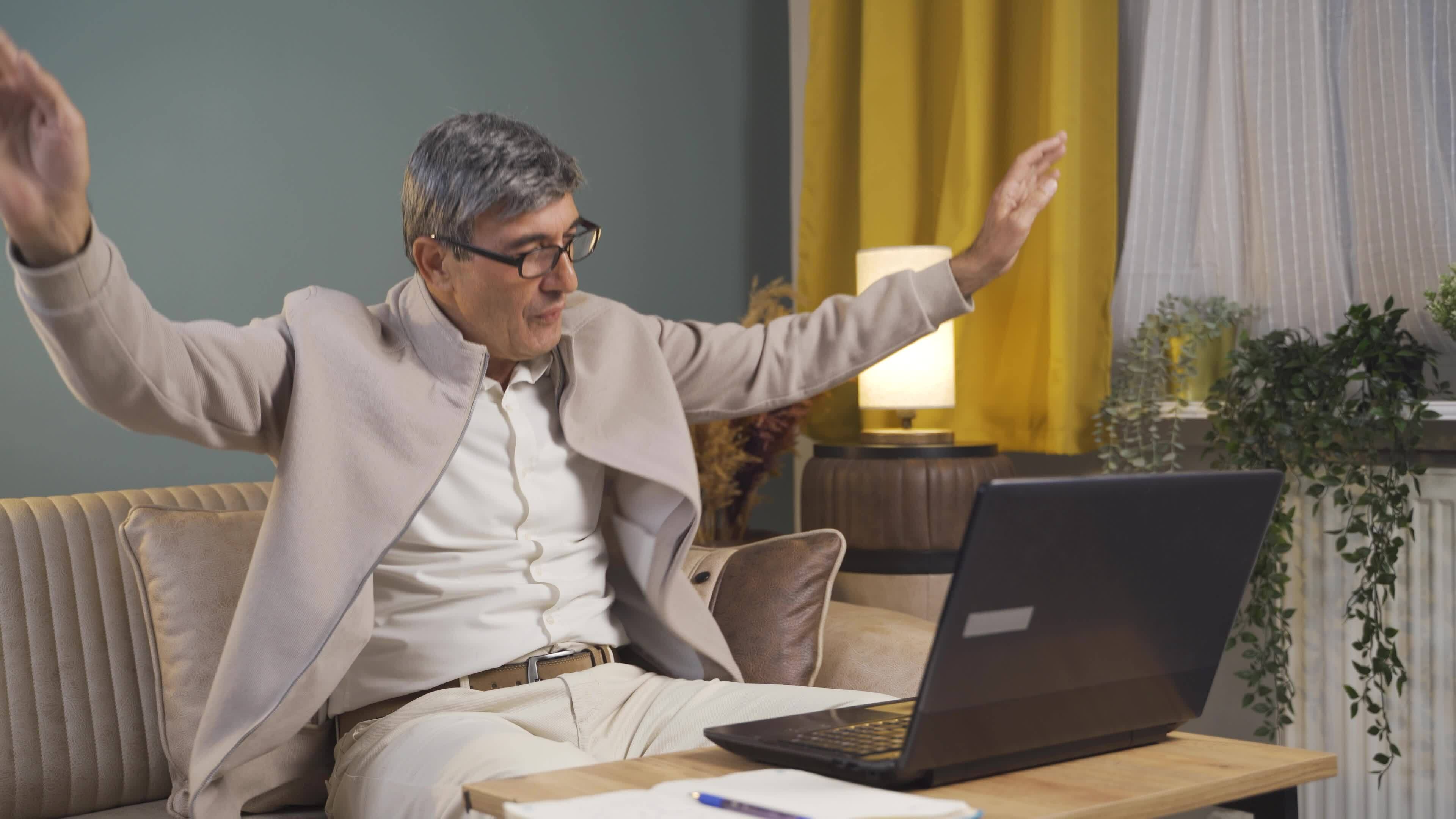 Old man looking at laptop is happy and dancing. 33500363 Stock Video at ...