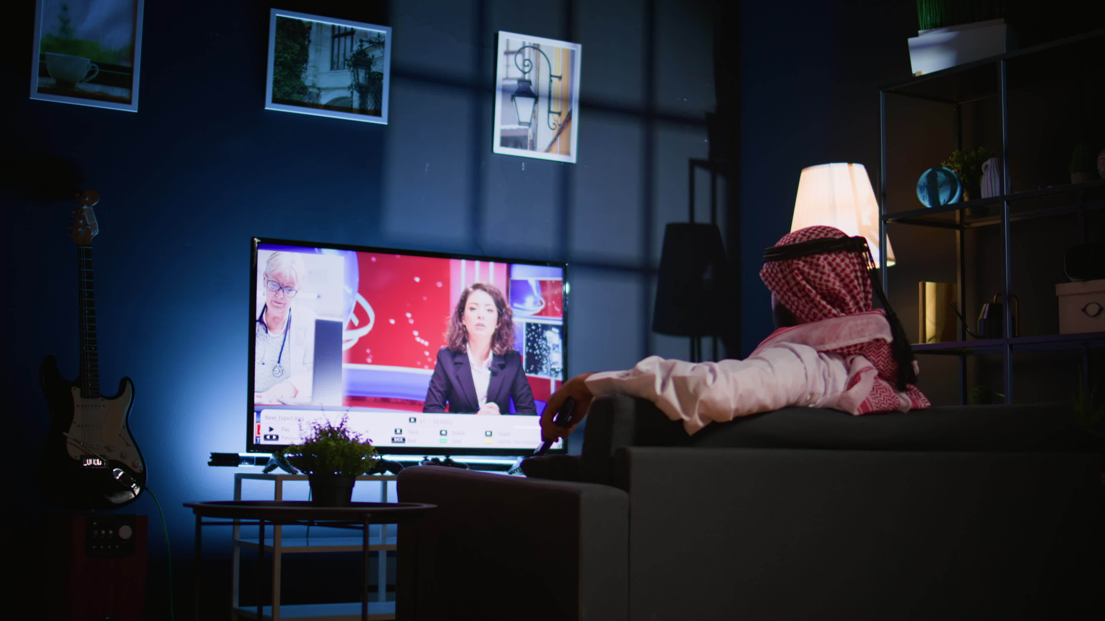 Arabic man lounged on sofa, watching news broadcast while relaxing in ... Arabic man lounged on sofa, watching news broadcast while relaxing in ...