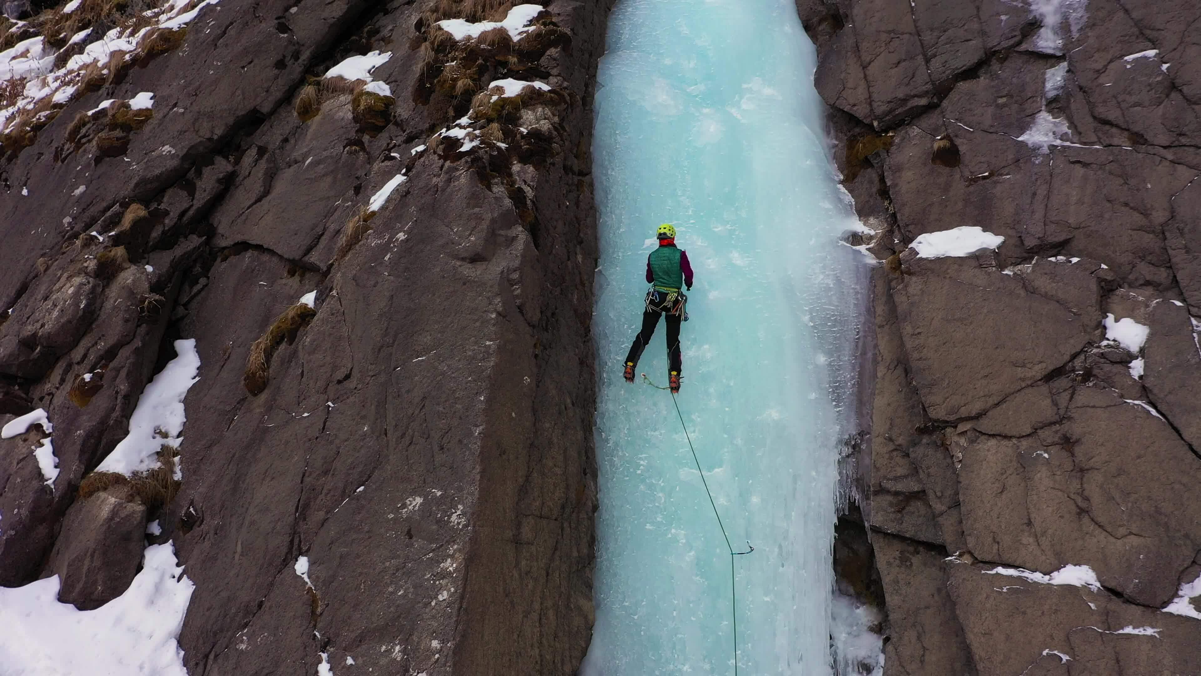 Ice Climbing on Frozen Waterfall. Mountaineer Woman is leading on Ice ...