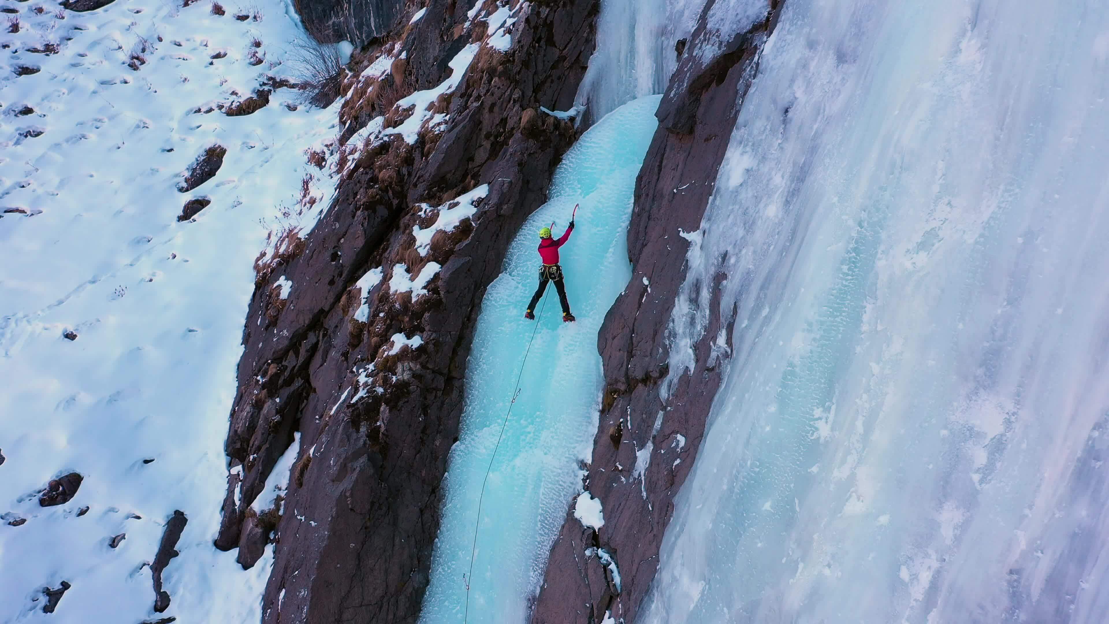 Ice Climbing on Frozen Waterfall. Mountaineer Woman is leading on Ice ...