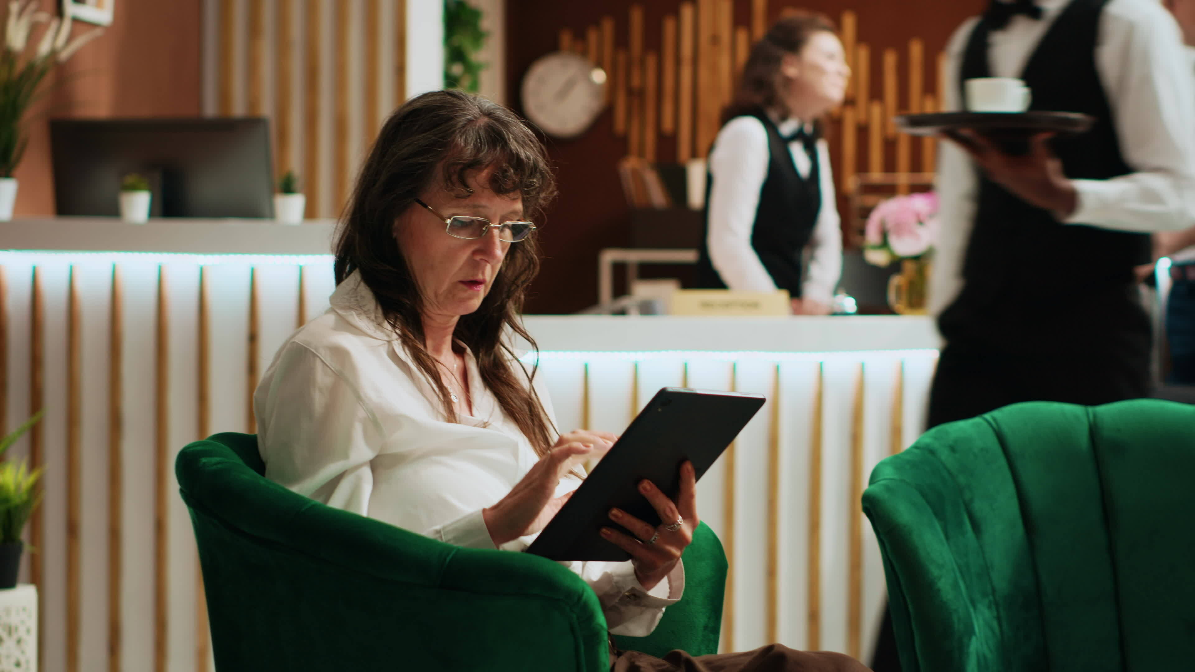 Hotel guest using modern device in lounge area, waiting for check in ... Hotel guest using modern device in lounge area, waiting for check in ...