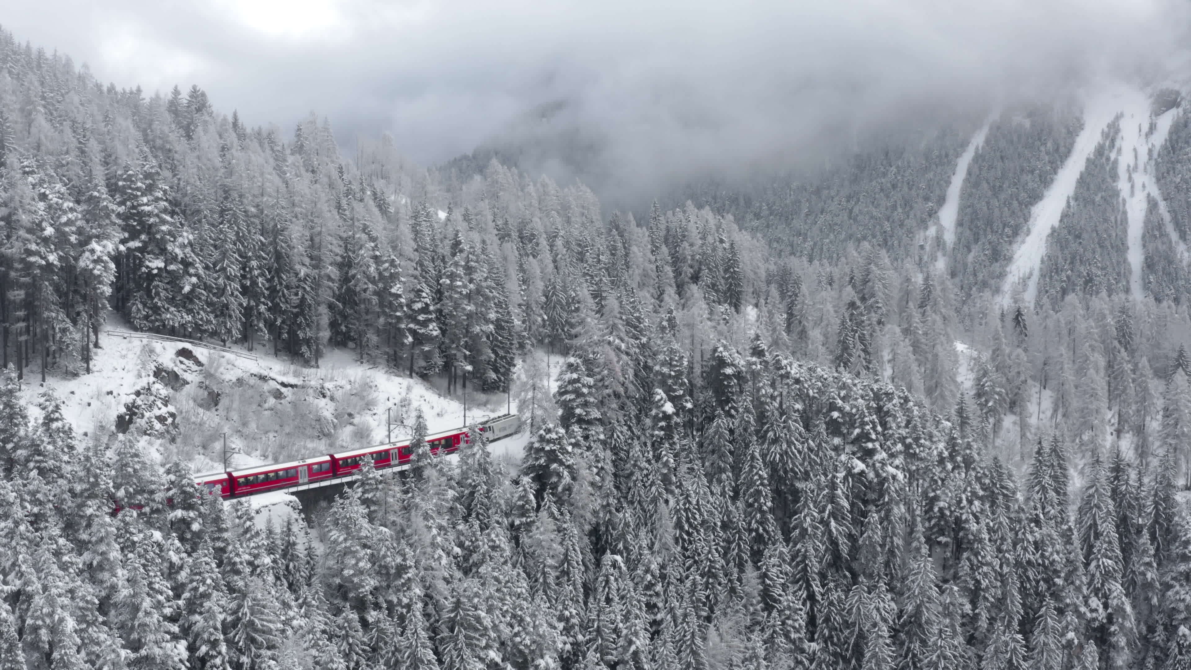 Aerial video of famous train of red color Glacier Express at winter ...