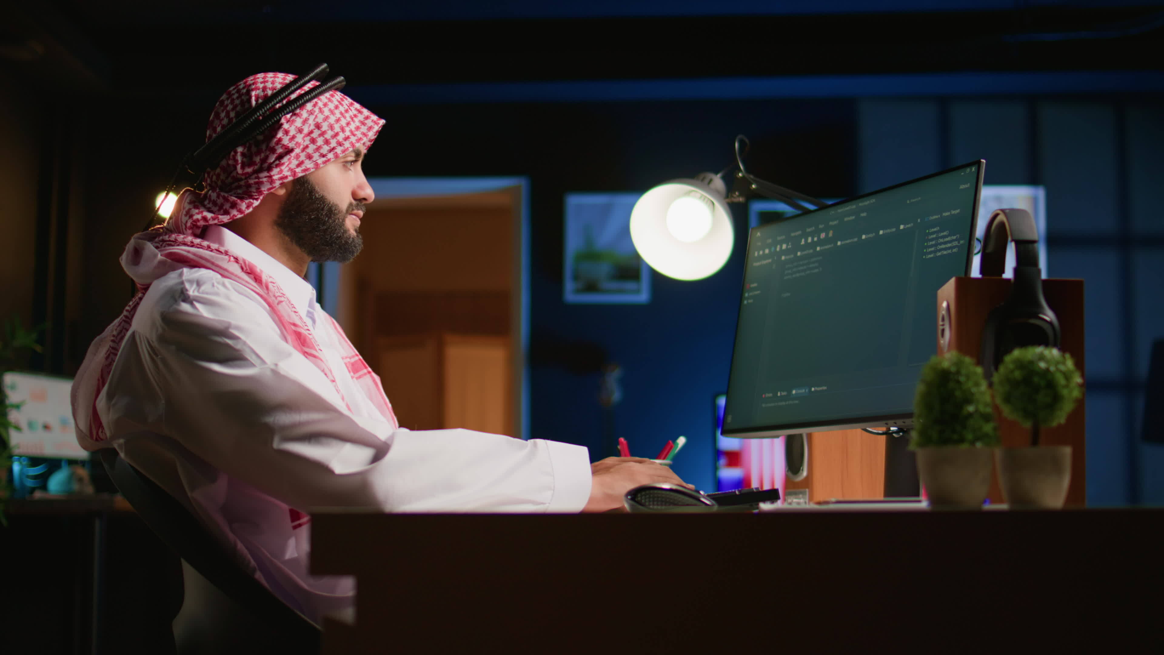 Smiling muslim engineer writing script code on computer screen using ... Smiling muslim engineer writing script code on computer screen using ...