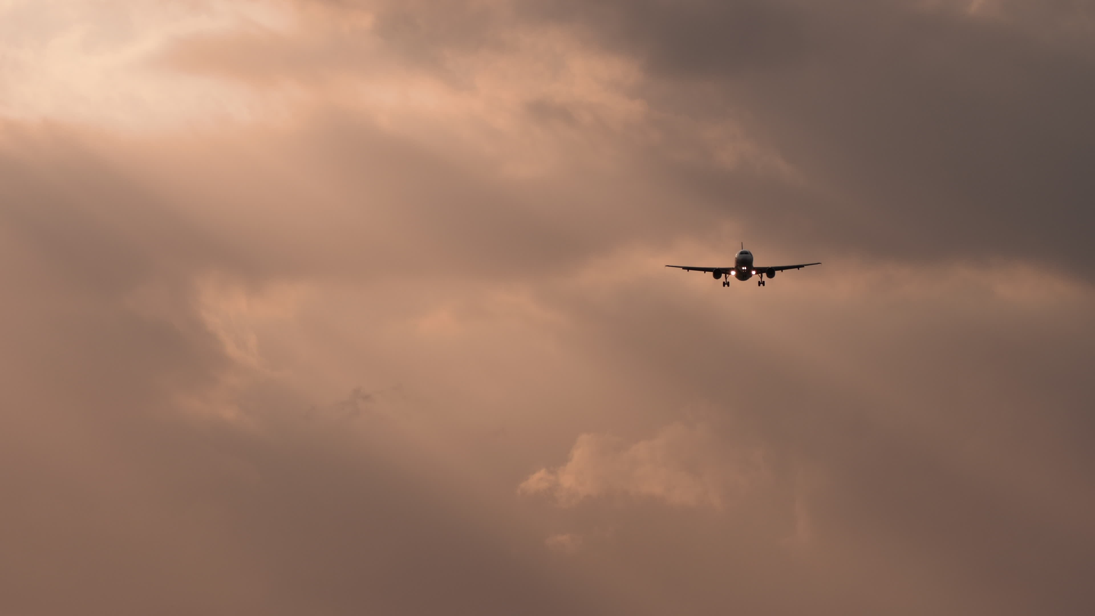 Airplane Approaching Before Landing In Cloudy Twilight Sky Jet Plane