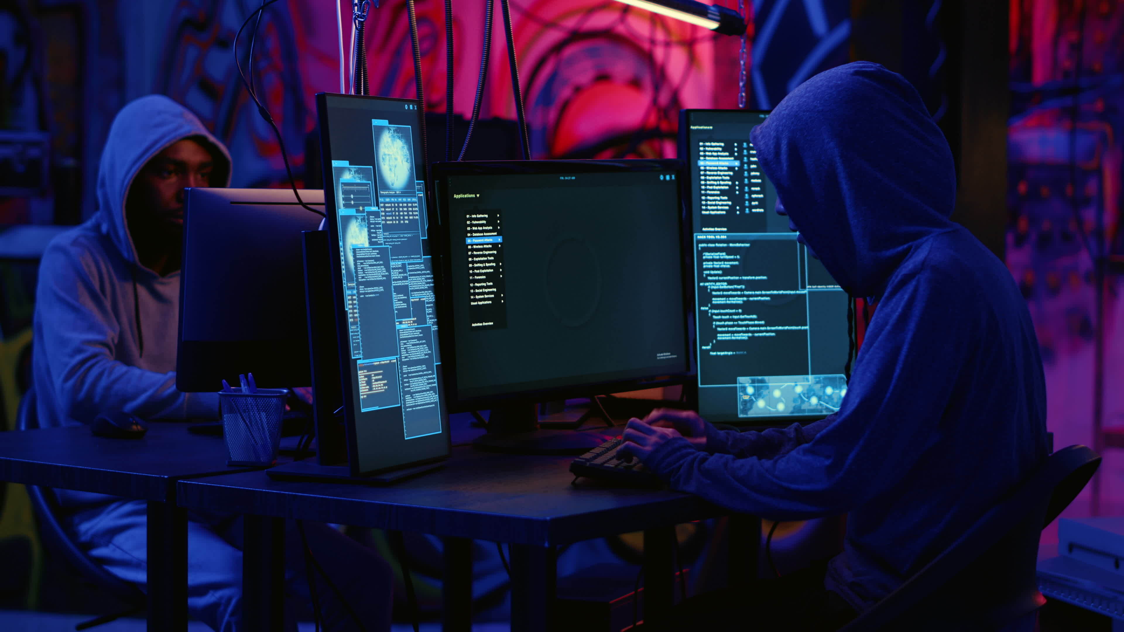 African American Hacker And Asian Colleague Working Together In Hidden