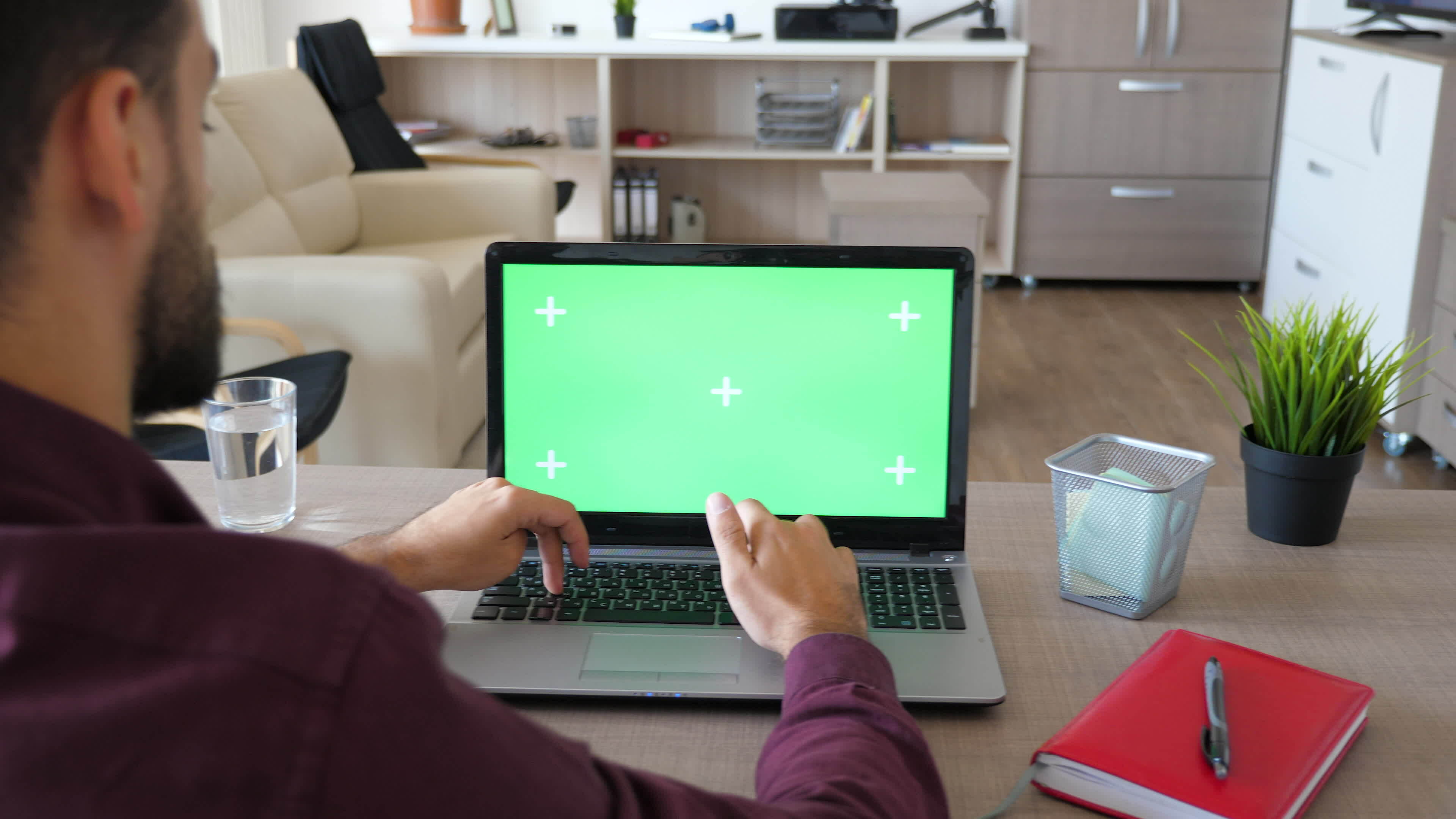 Man typing on computer with green screen chroma mock up in his ...