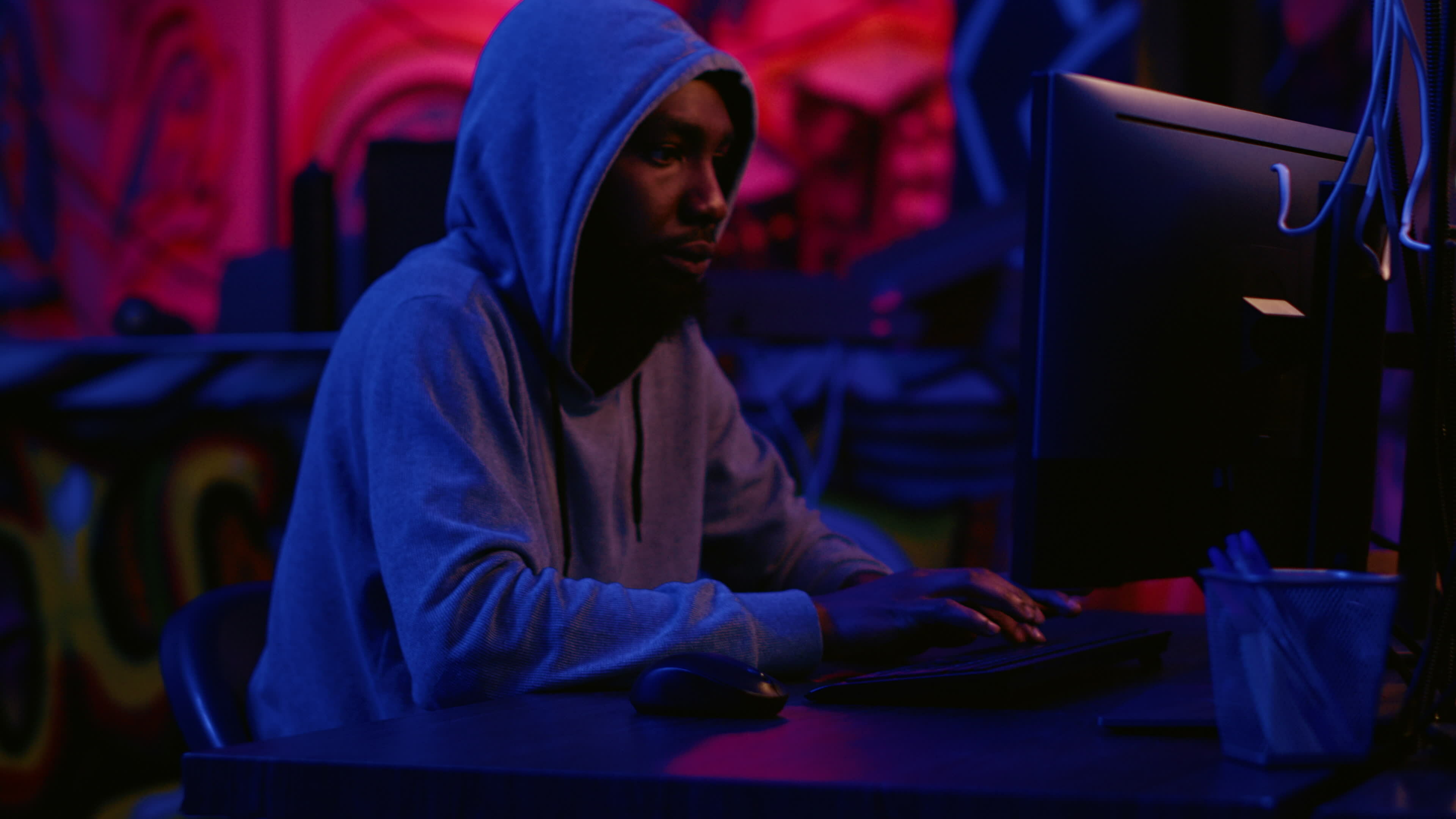 Hacker In Secret Dark Room Writing Lines Of Code On Computer