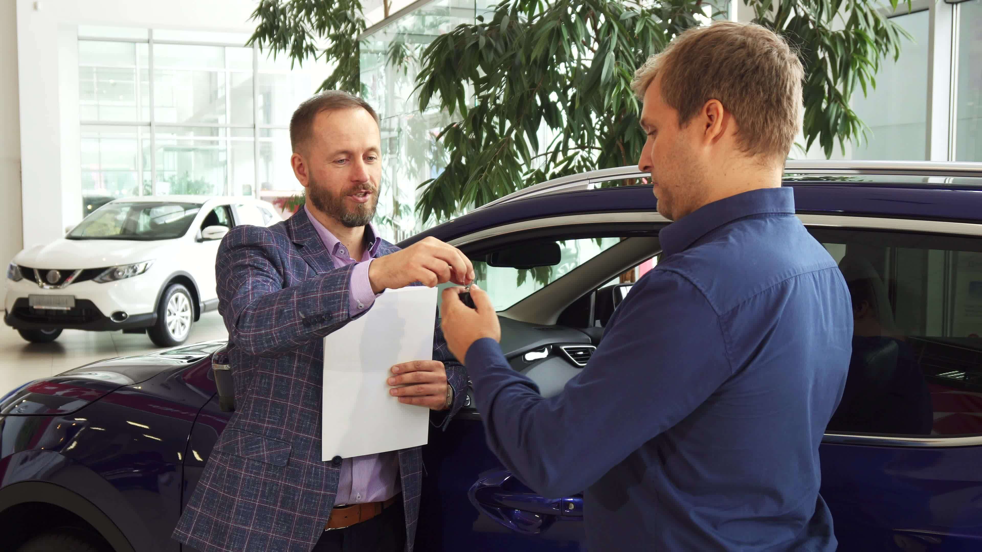 Car dealer hands over the keys to the new owner 35290683 Stock Video at Vecteezy