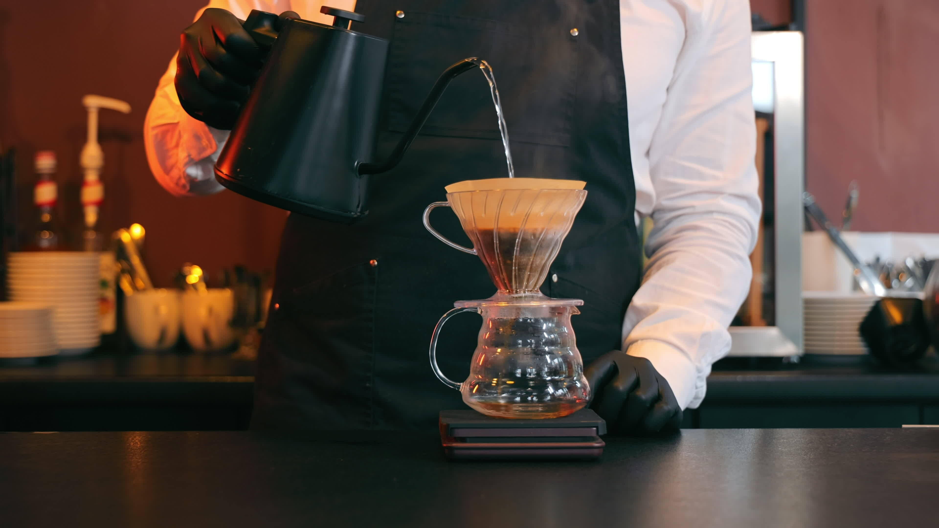 Preparation of coffee. The barista pours boiling water over the coffee ...