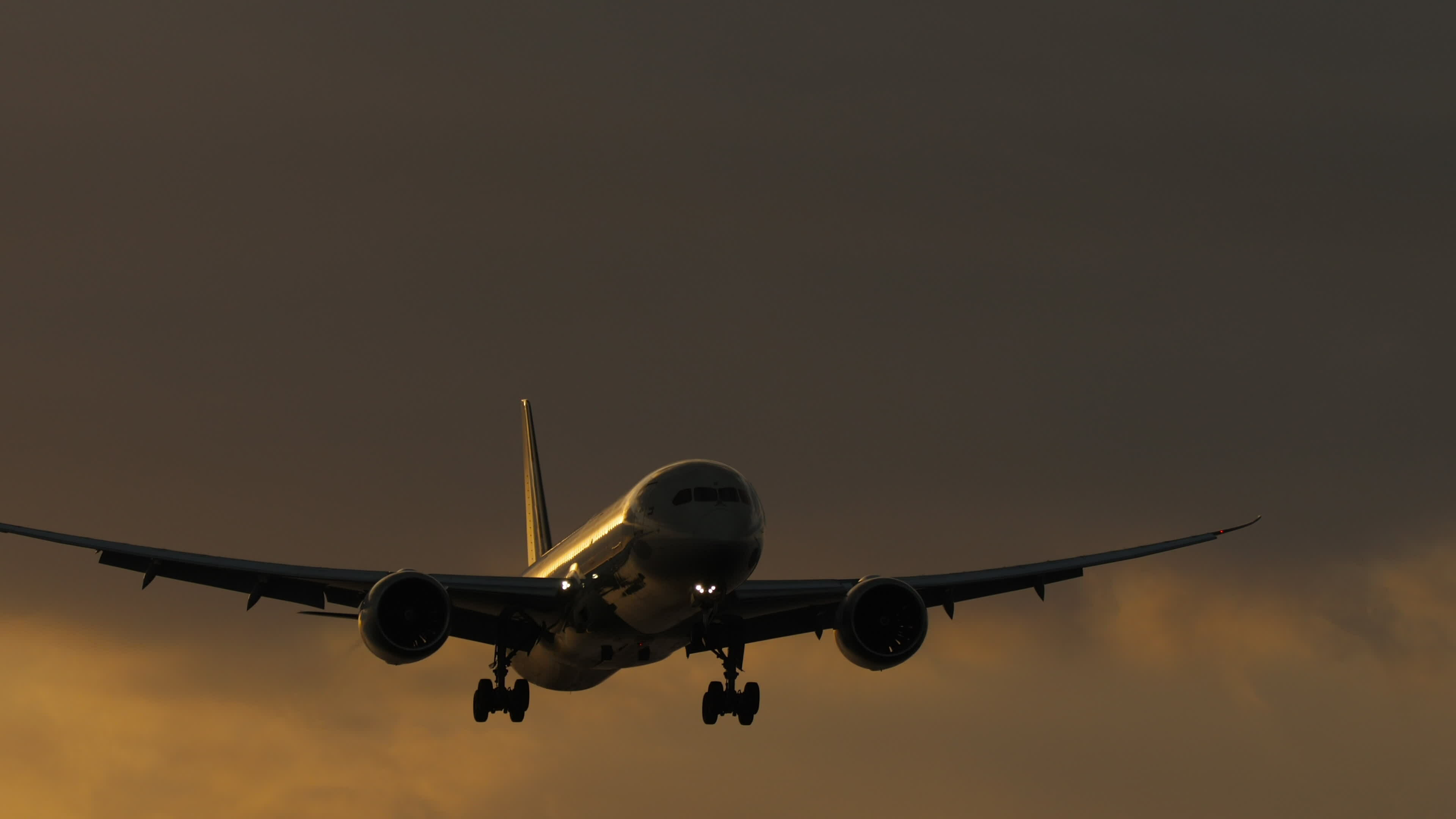 Jet Airplane Approaching To Land In The Sunset Sky Long Shot Static