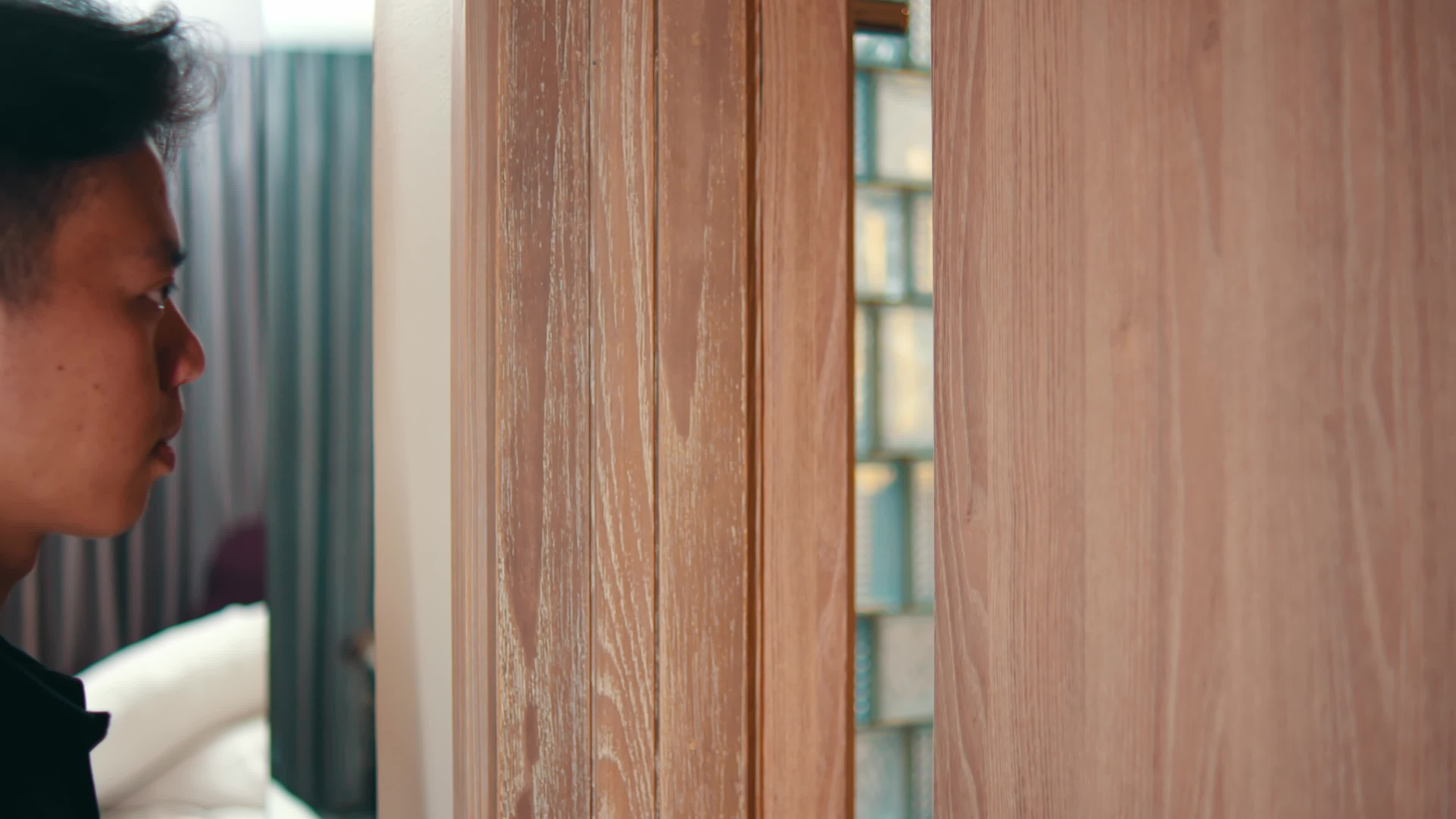 an Asian man is spying on his girlfriend while in the bathroom of a hotel room 35611217 Stock ...