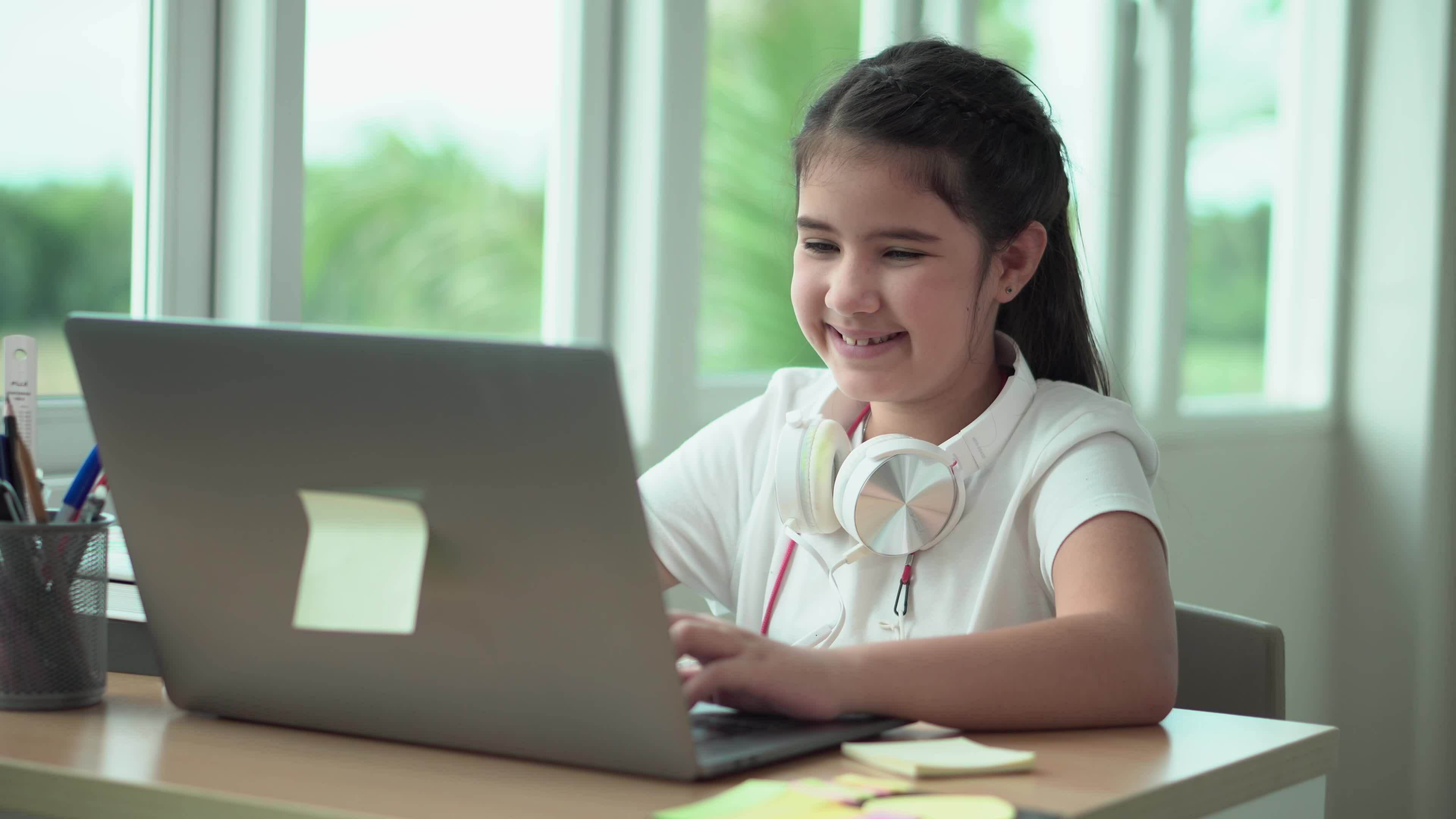 Kid girl smile enjoy e-learning on computer notebook with for laugh to ...