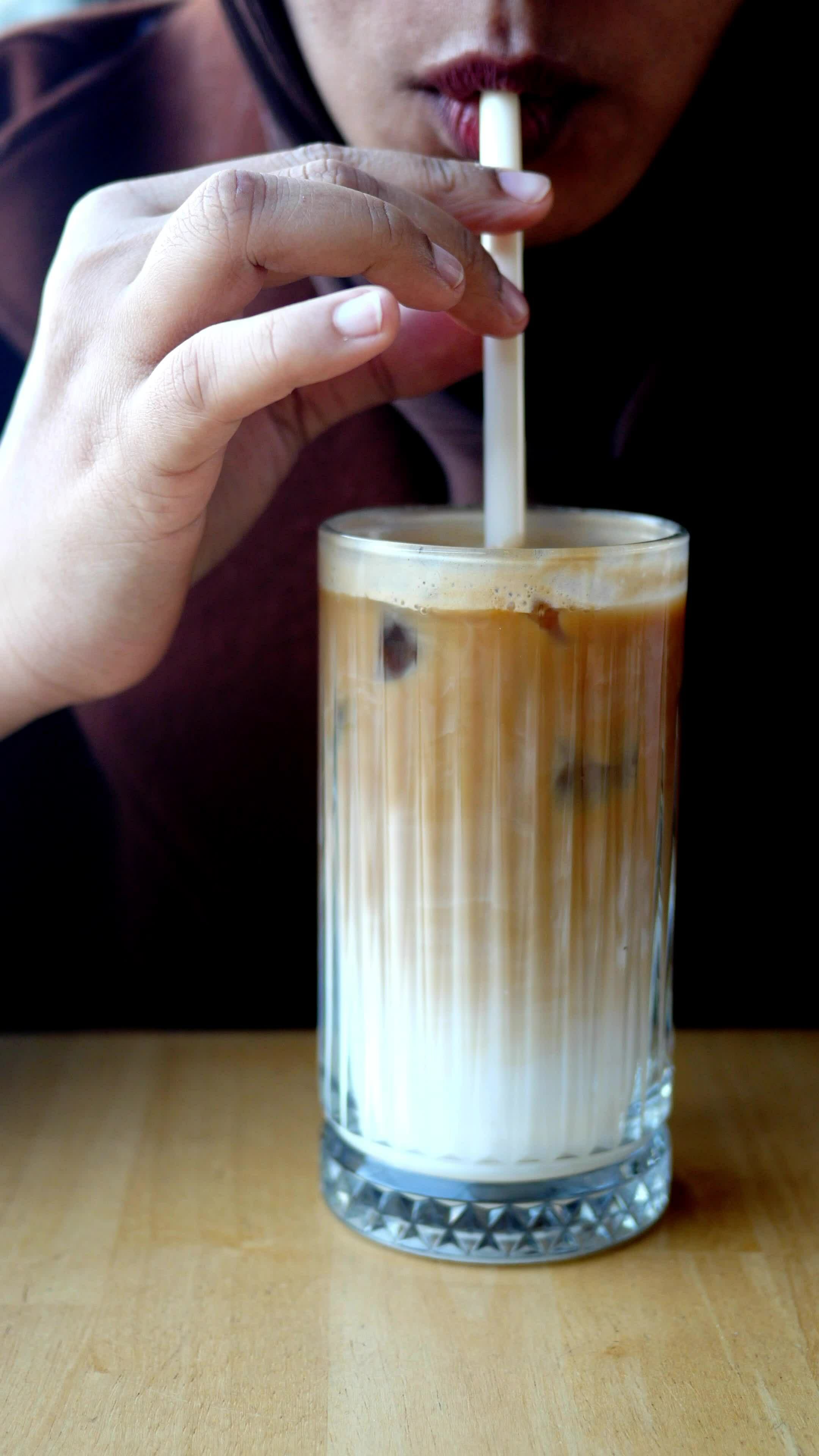 women drinking iced late in a transparent glass on cafe table outdoor 36398755 Stock Video at ...