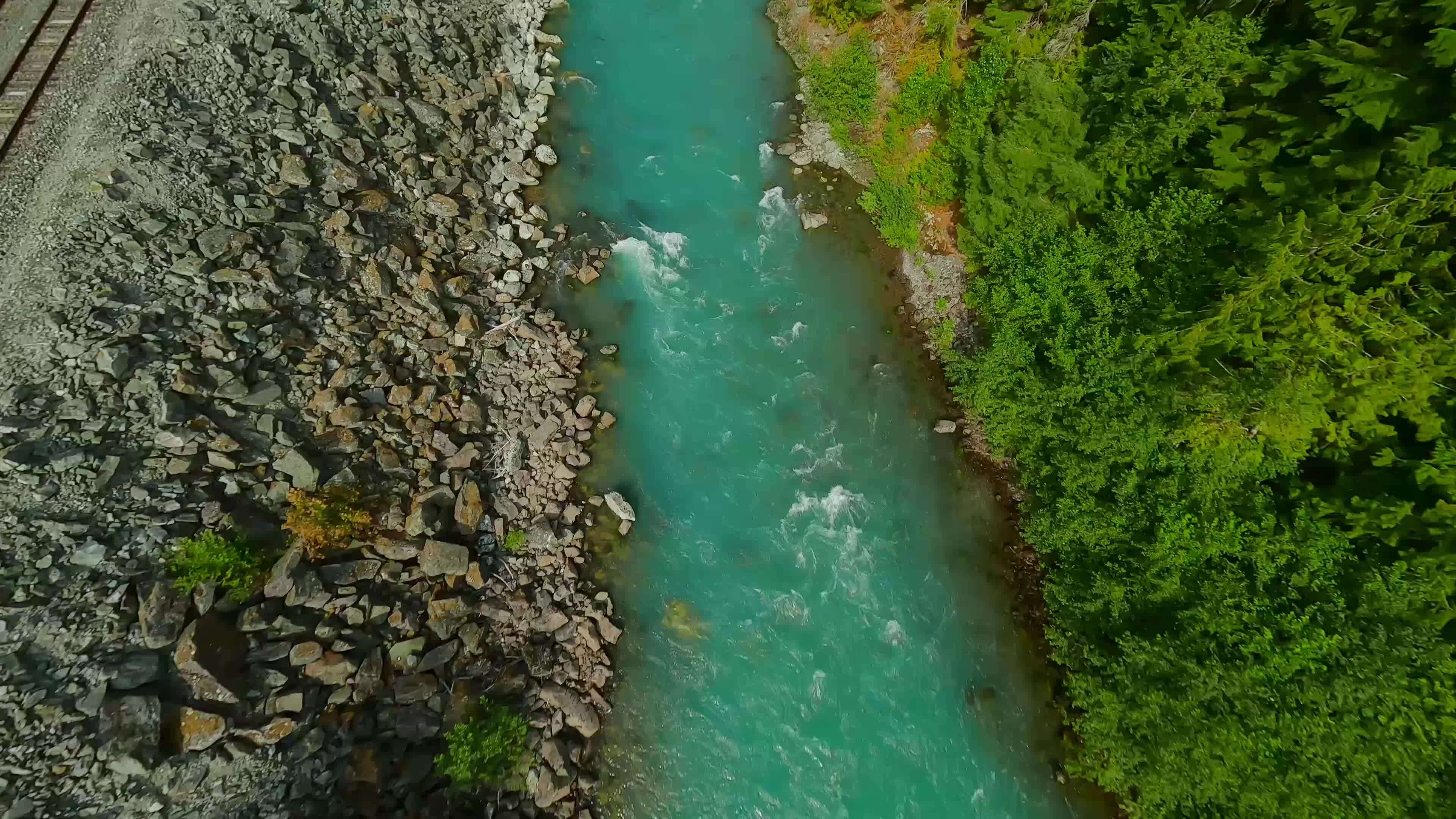 FPV drone flight over the fast moving river with rapids, close to the ...