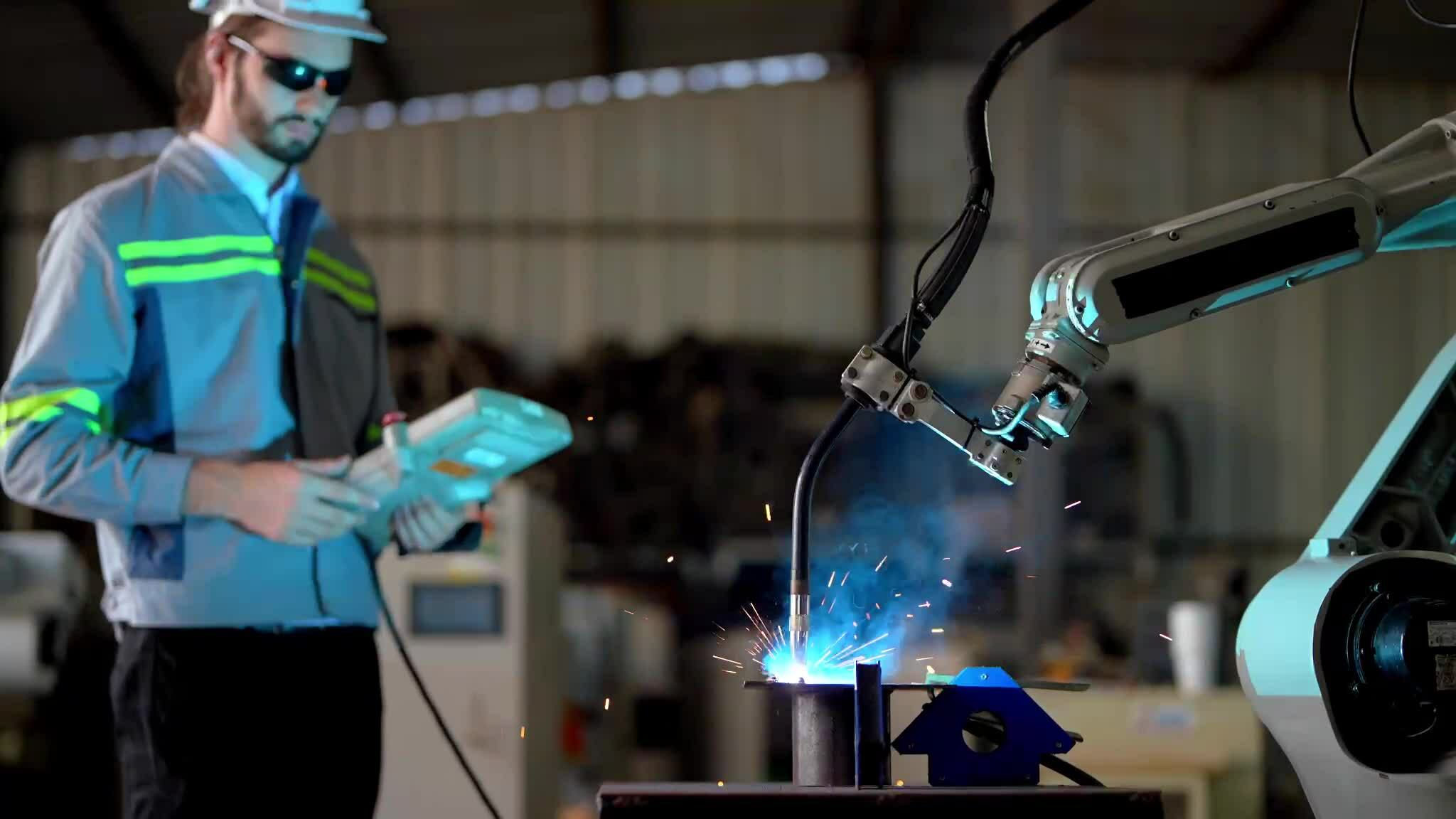 Factory Engineers Using Smart Control To Control The Arm Robot Machine For Cutting The Metal