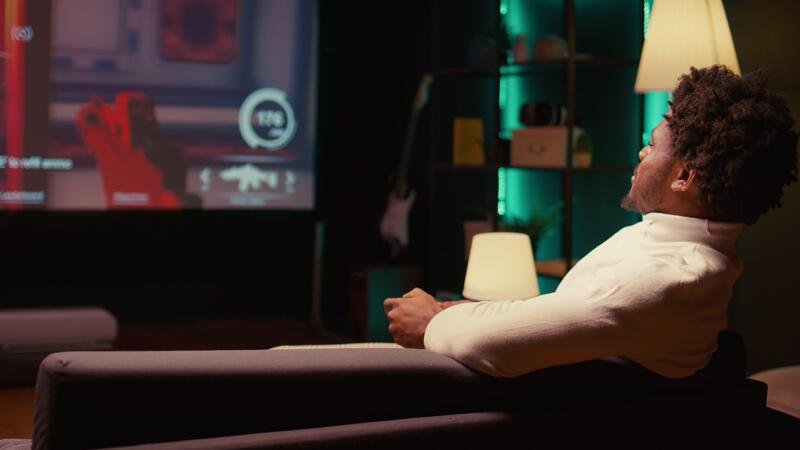 Bipoc Man Playing Sf Fps Videogame On Ultrawide Smart Tv Having Fun In