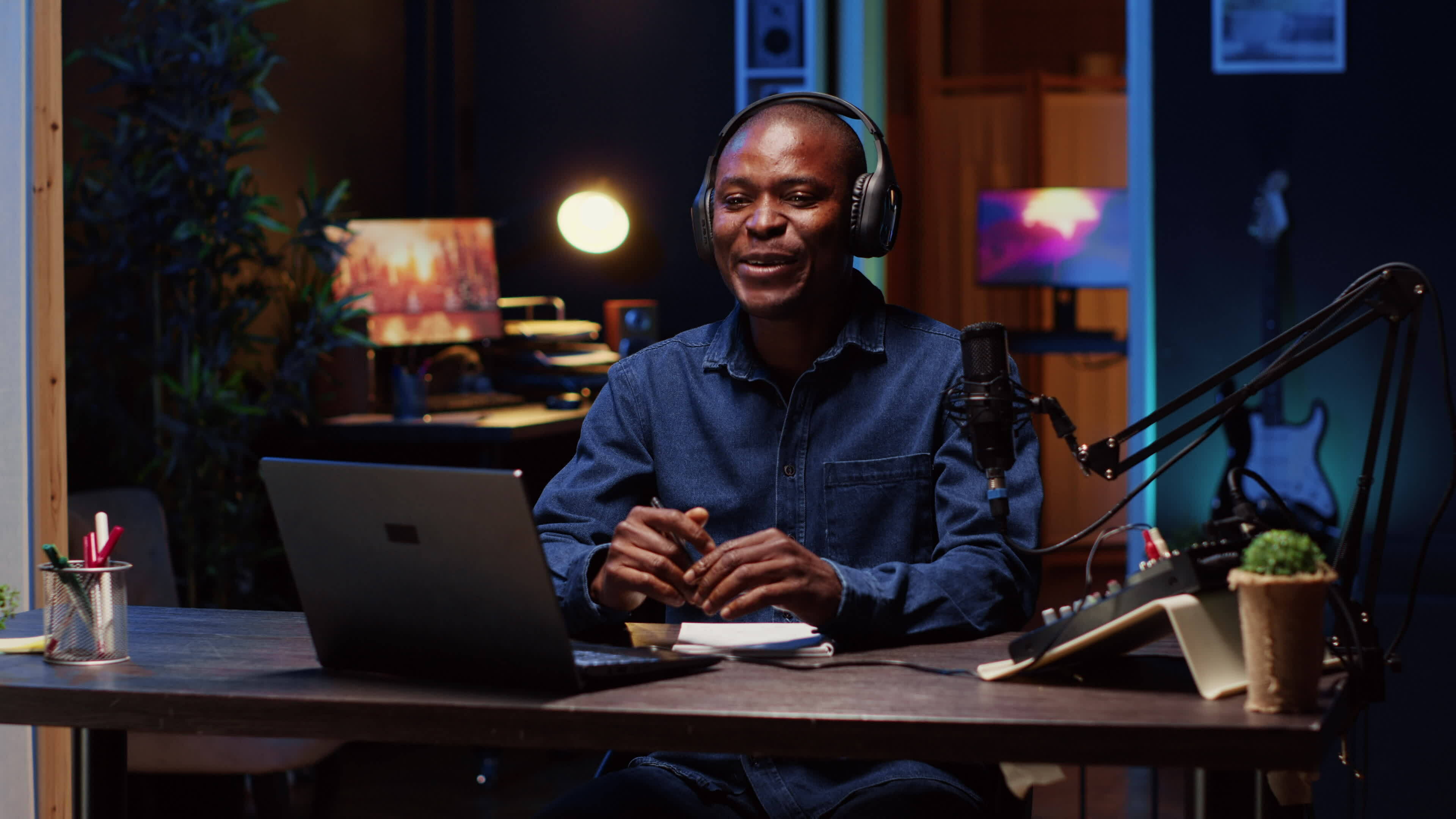 Cheerful content creator using outlined ideas on notebook to film vlog ...