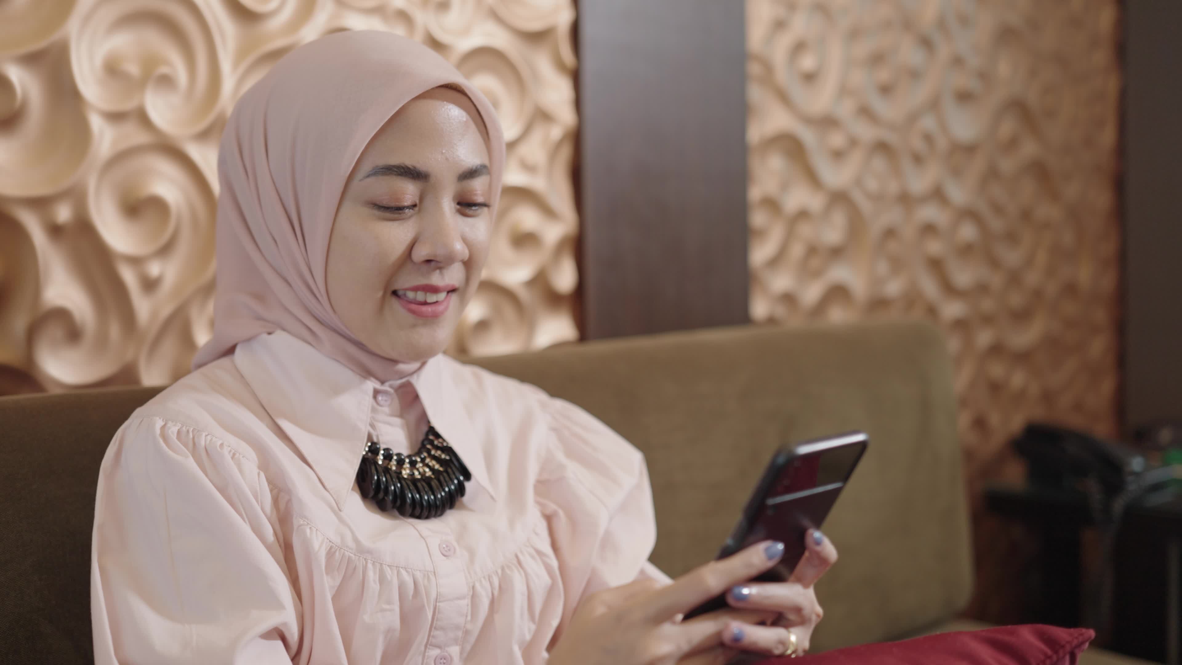 Modern Muslim Woman on Hijab Southeast Asian - Smiling, Looking and Scrolling her Smartphone ...