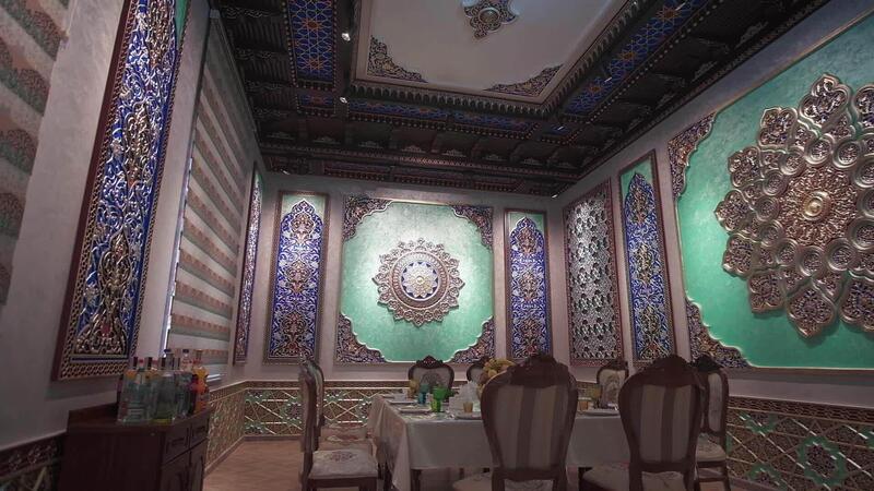 Dining room with richly colored walls and ceiling with Arabic-oriental ...
