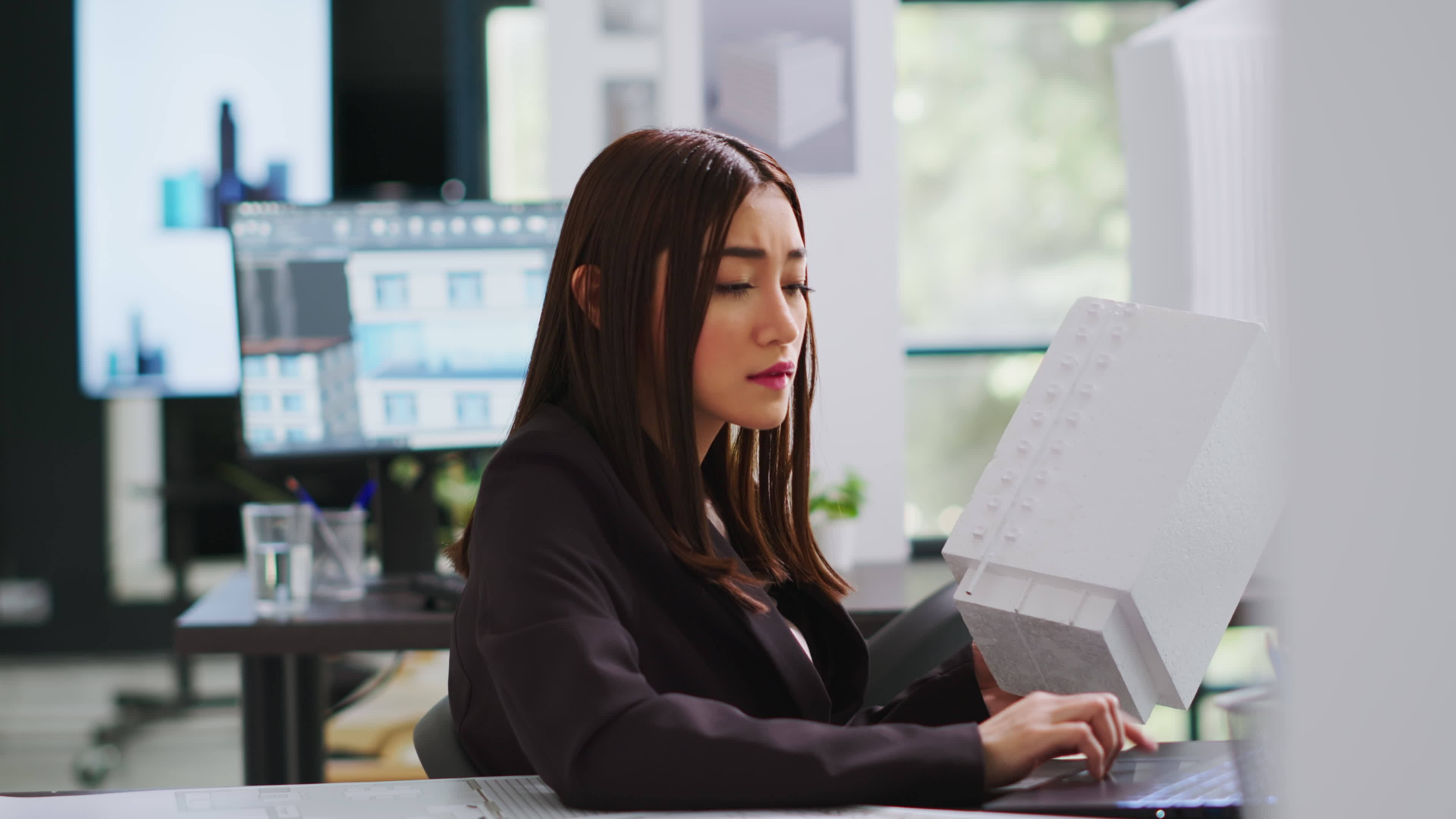 Developer analyzing 3d building model at realty office, examining measurements for the actual ...