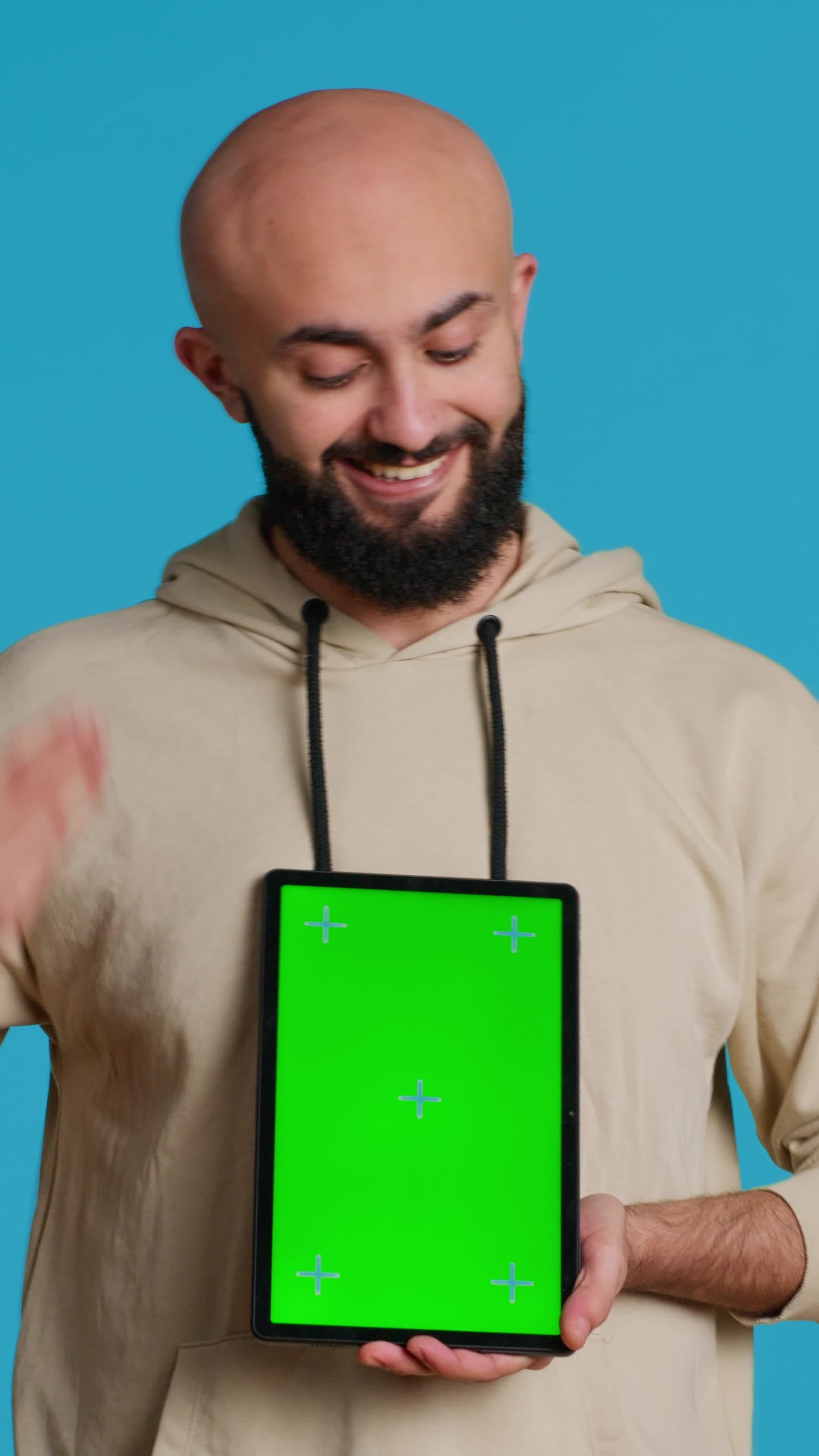 Vertical Video Muslim person holding tablet with greenscreen template, presenting isolated ...