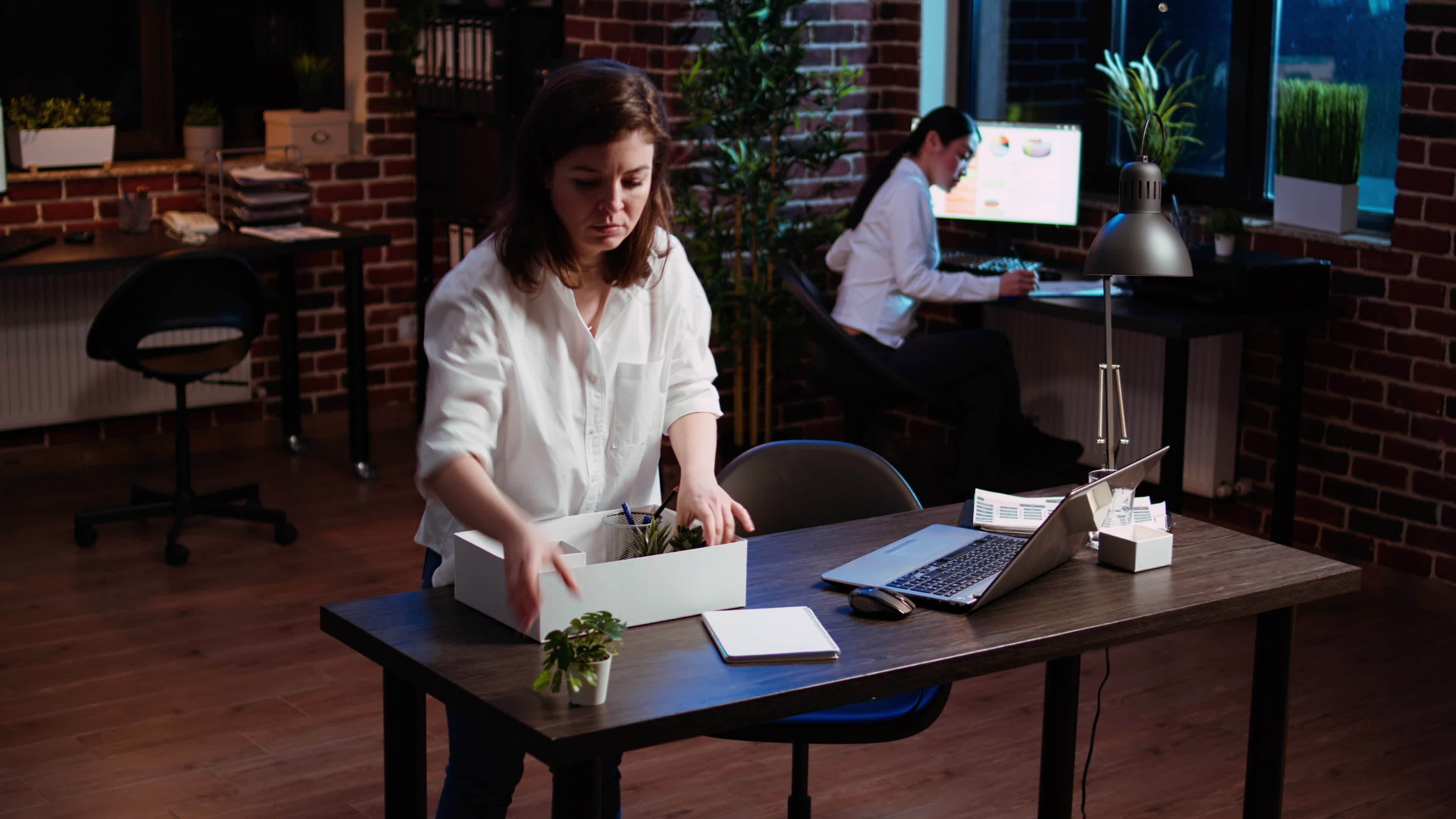 Frustrated employee packing desk belongings after being fired, saying goodbye to coworker. Upset ...