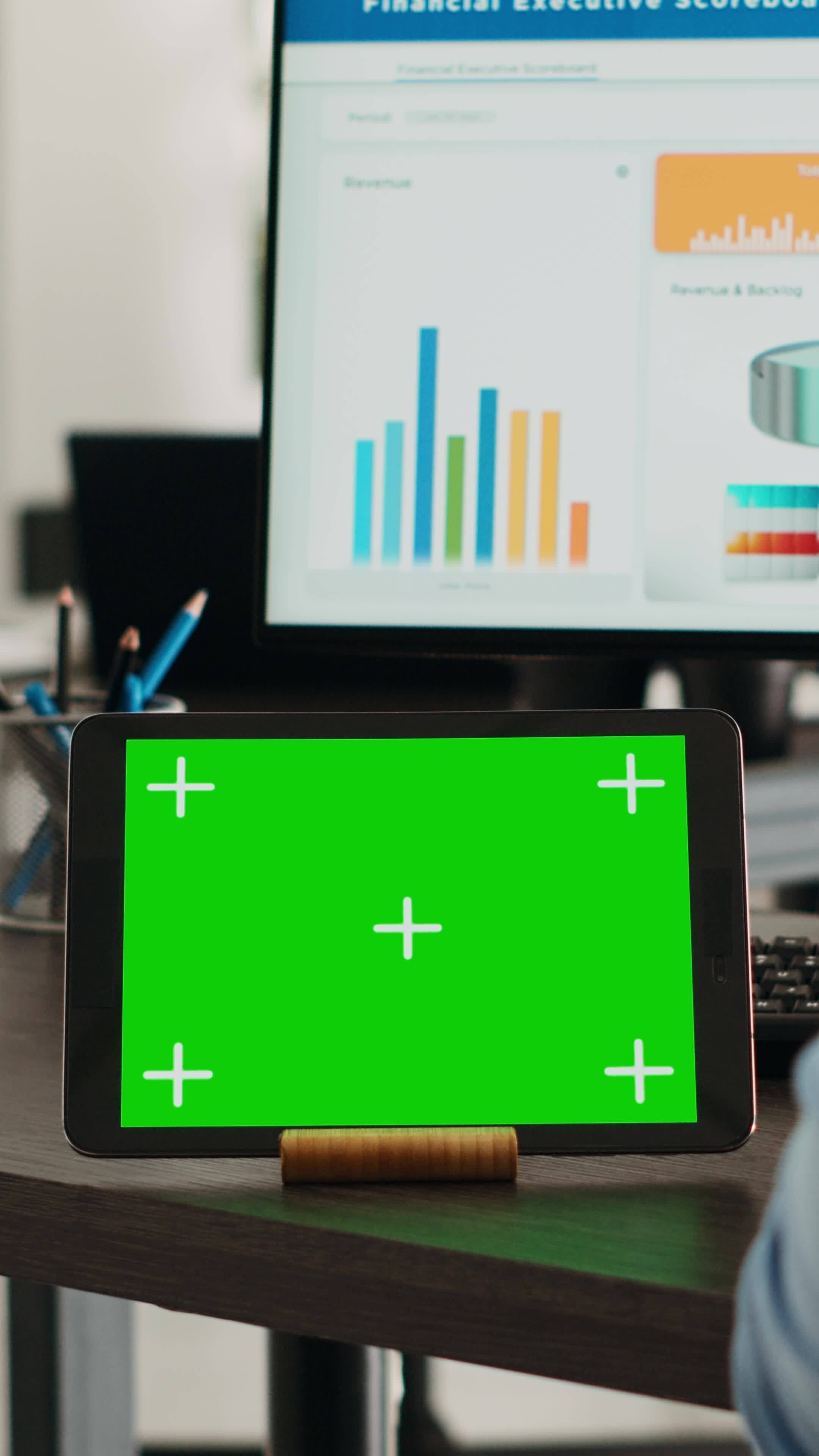 Vertical Video Company Employee Having Tablet On Desk With Greenscreen