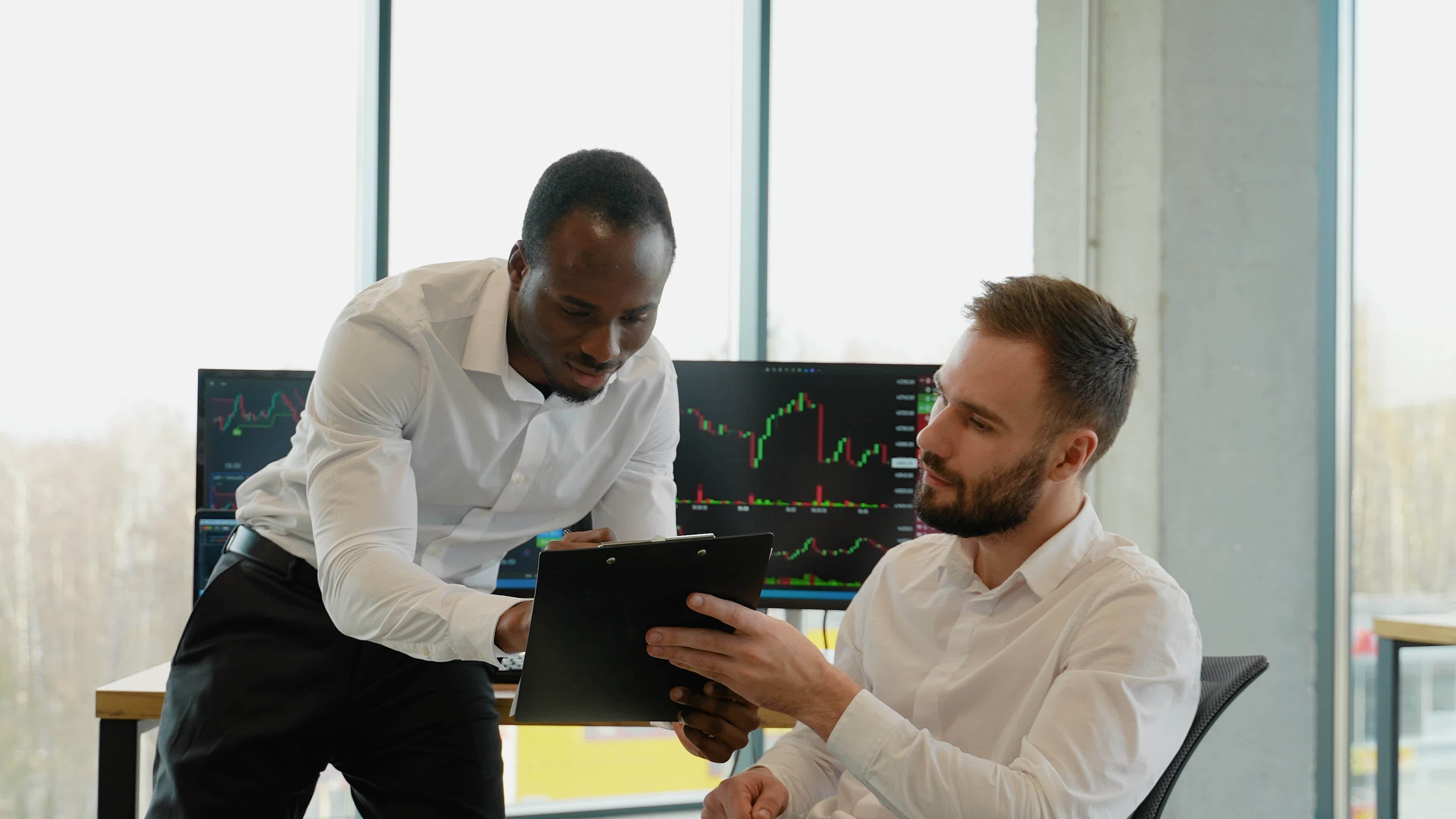 Two crypto traders making professional analysis of candlestick chart, creating strategy, holding ...