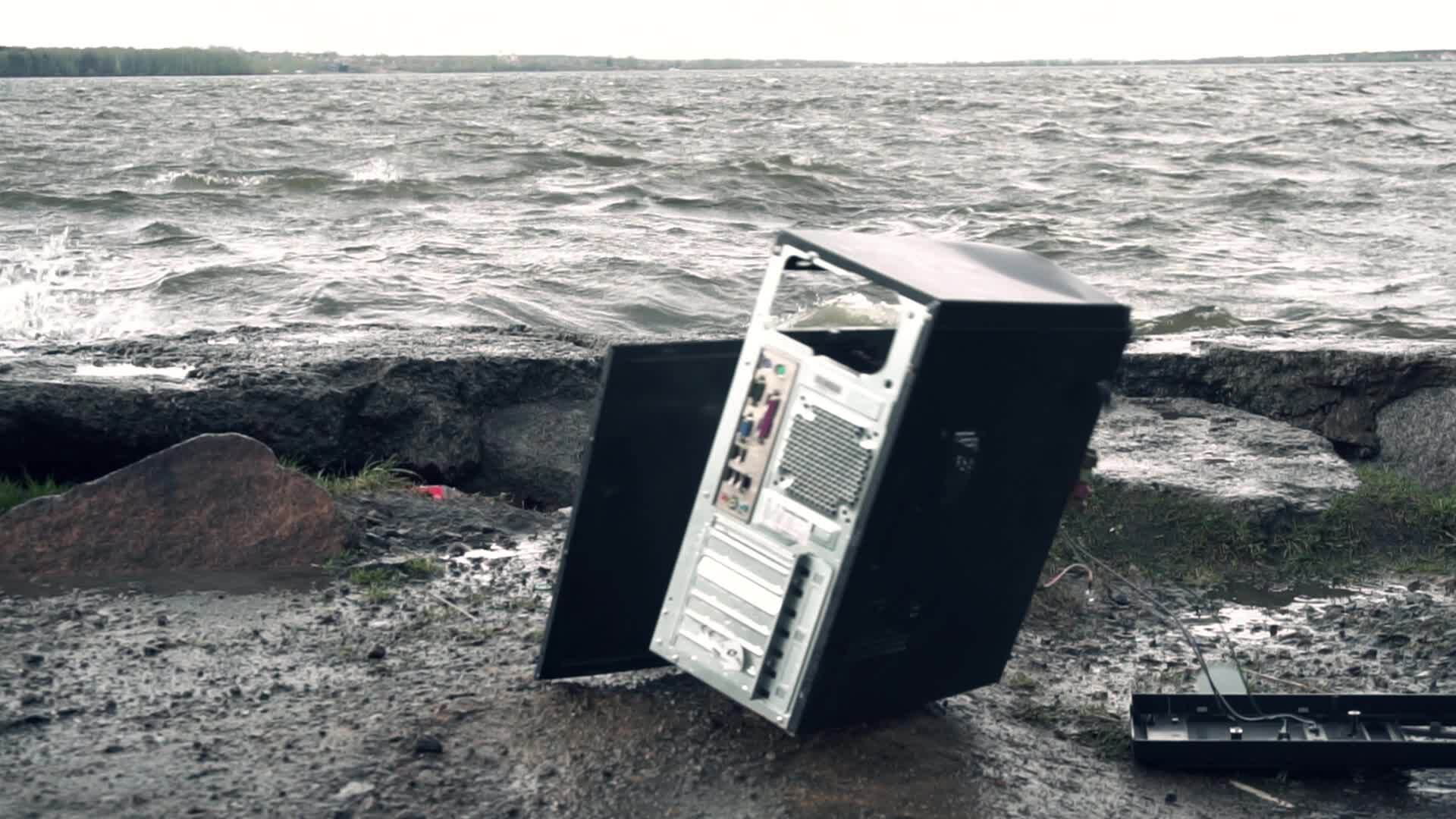 Man breaks a computer with a sledgehammer. A man destroys a computer on ...