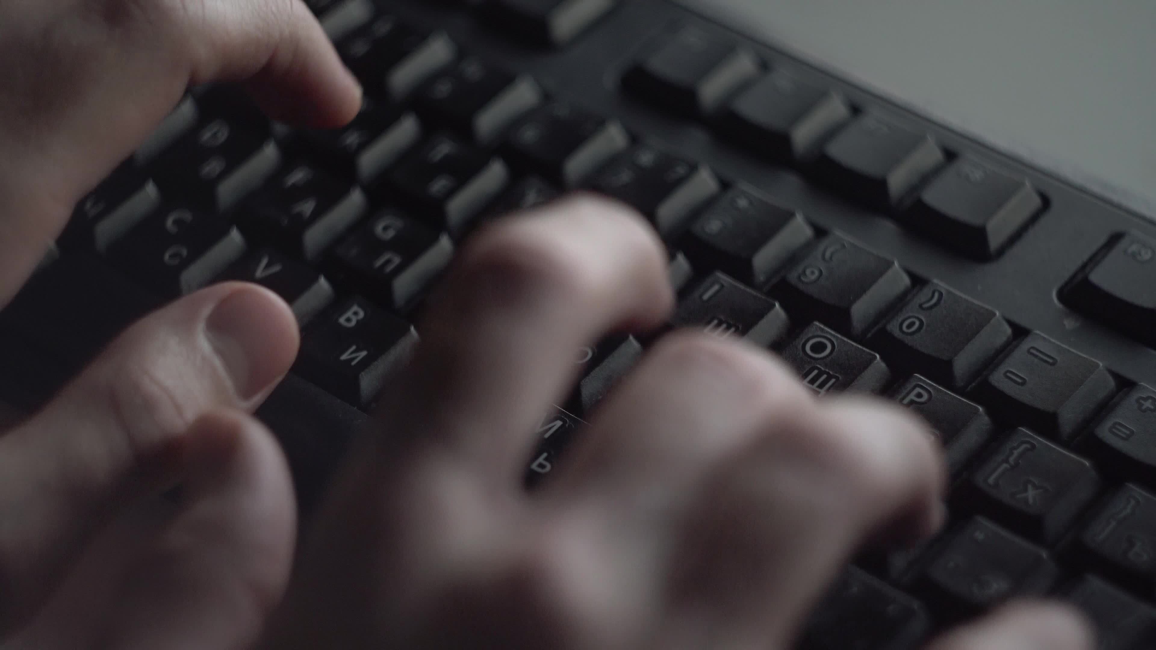 Close-up of man typing on keyboard. Man typing with both hands on black ...