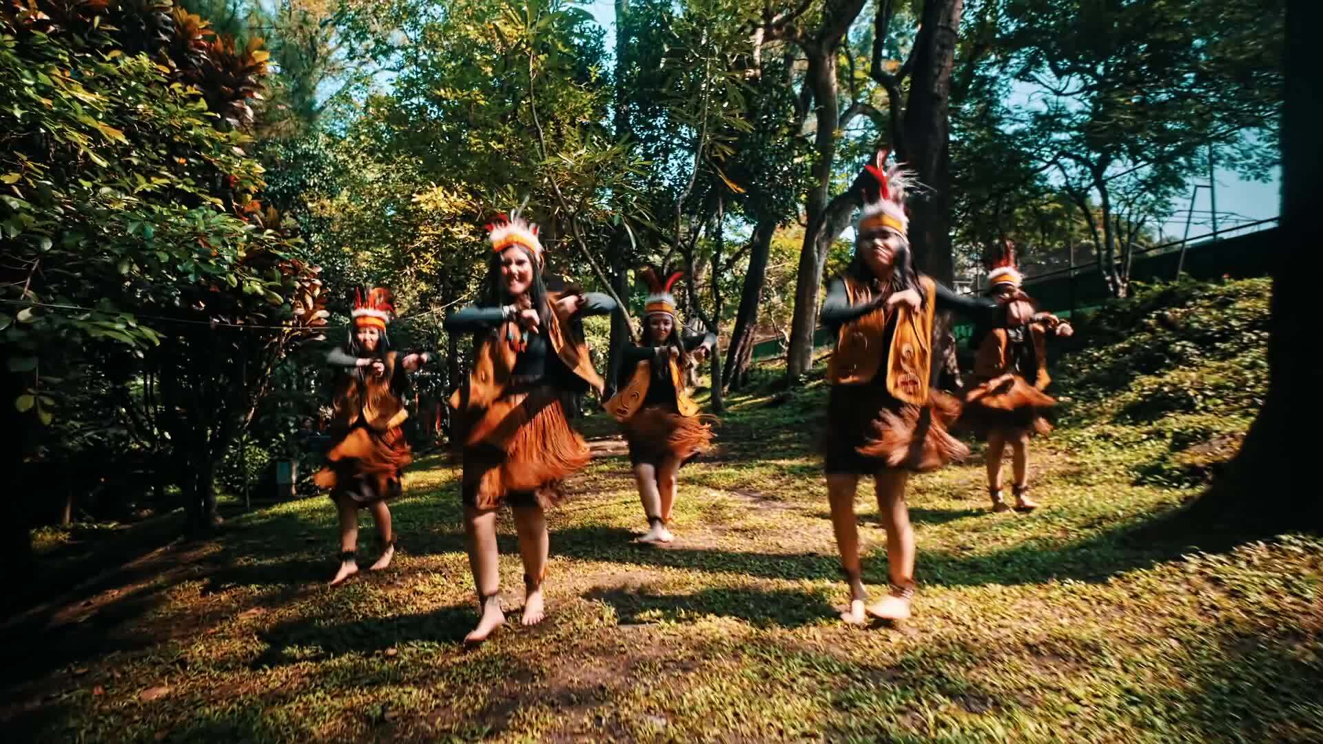 Indigenous People In Traditional Attire Performing A Cultural Dance In A Lush Forest Setting