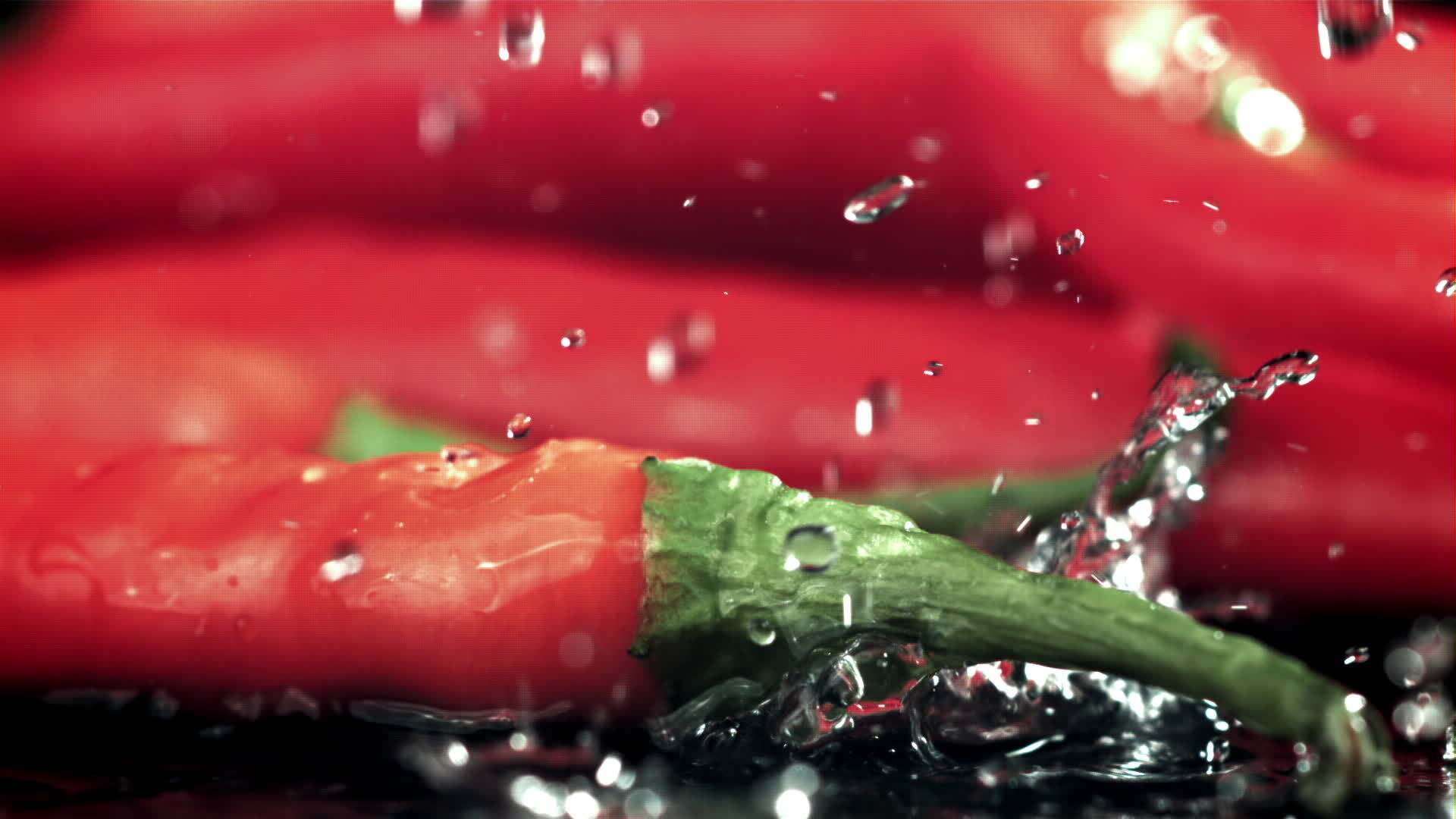 Drops of water fall on chili peppers. Filmed on a high-speed camera at 1000 fps. High quality ...