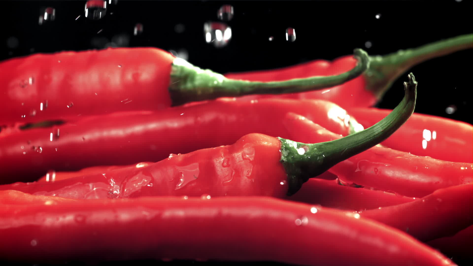 Drops of water fall on chili peppers. Filmed on a high-speed camera at 1000 fps. High quality ...