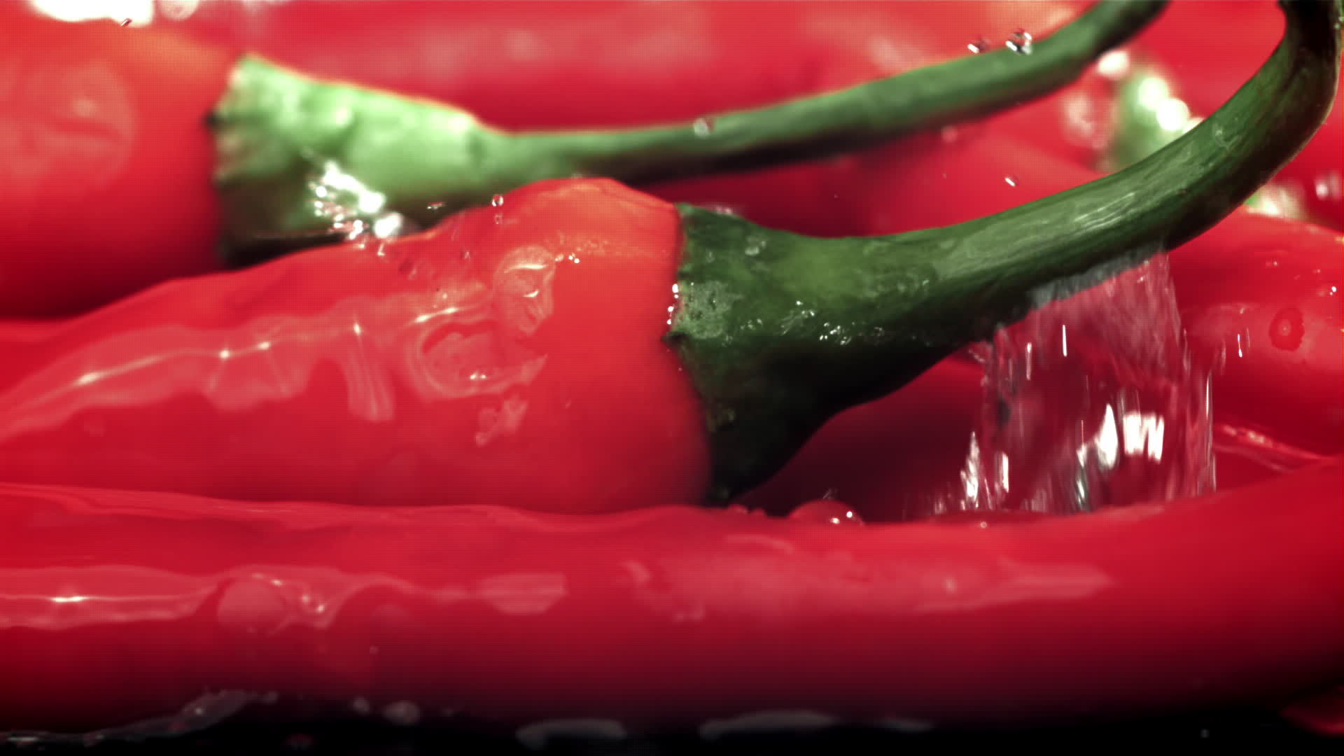 Drops of water fall on chili peppers. Filmed on a high-speed camera at 1000 fps. High quality ...