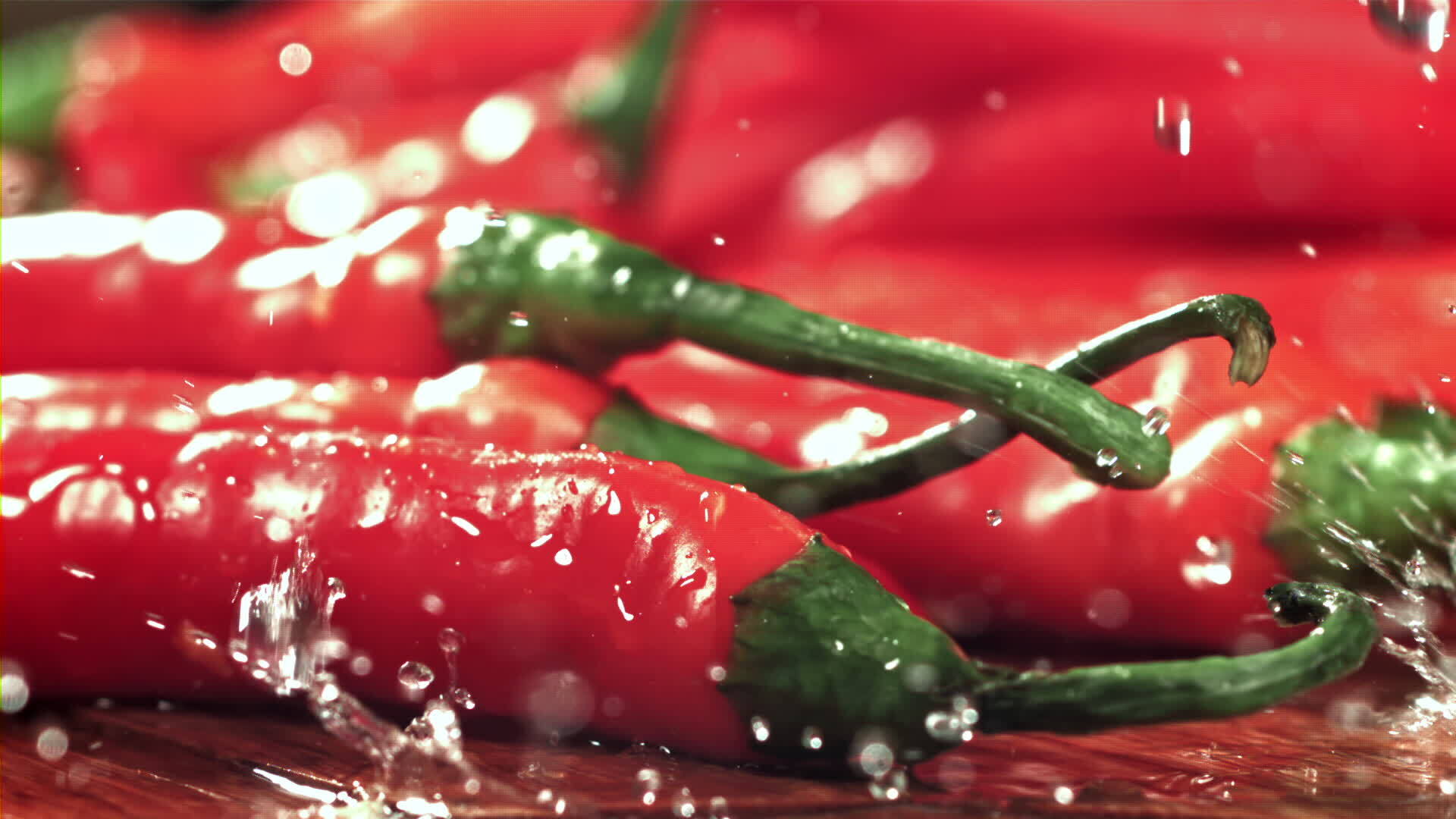 Drops of water fall on chili peppers. Filmed on a high-speed camera at 1000 fps. High quality ...