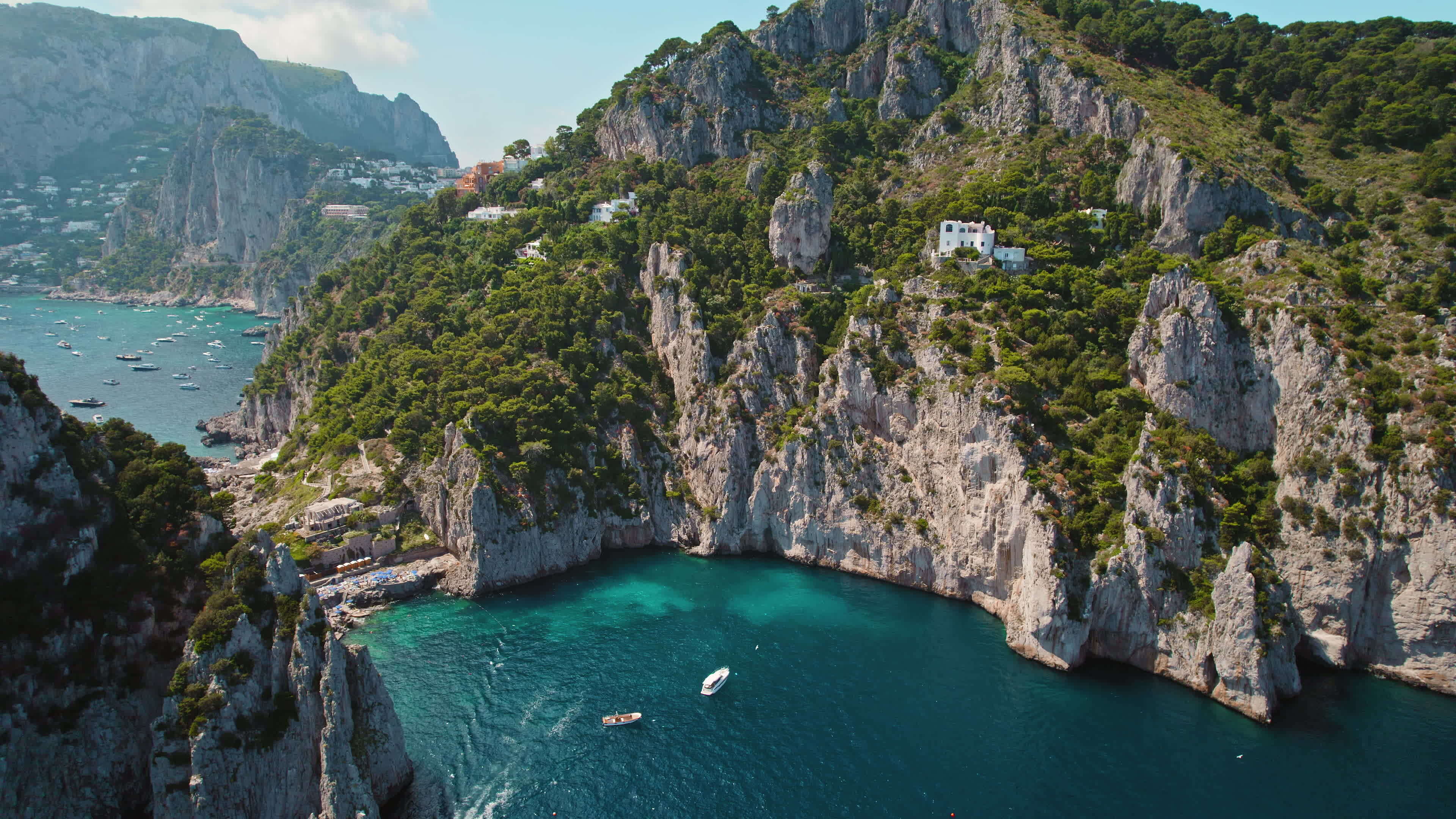 Cliffs on secluded cove with famous Da Luigi ai Faraglioni beach on Capri, italy. Sheer ...