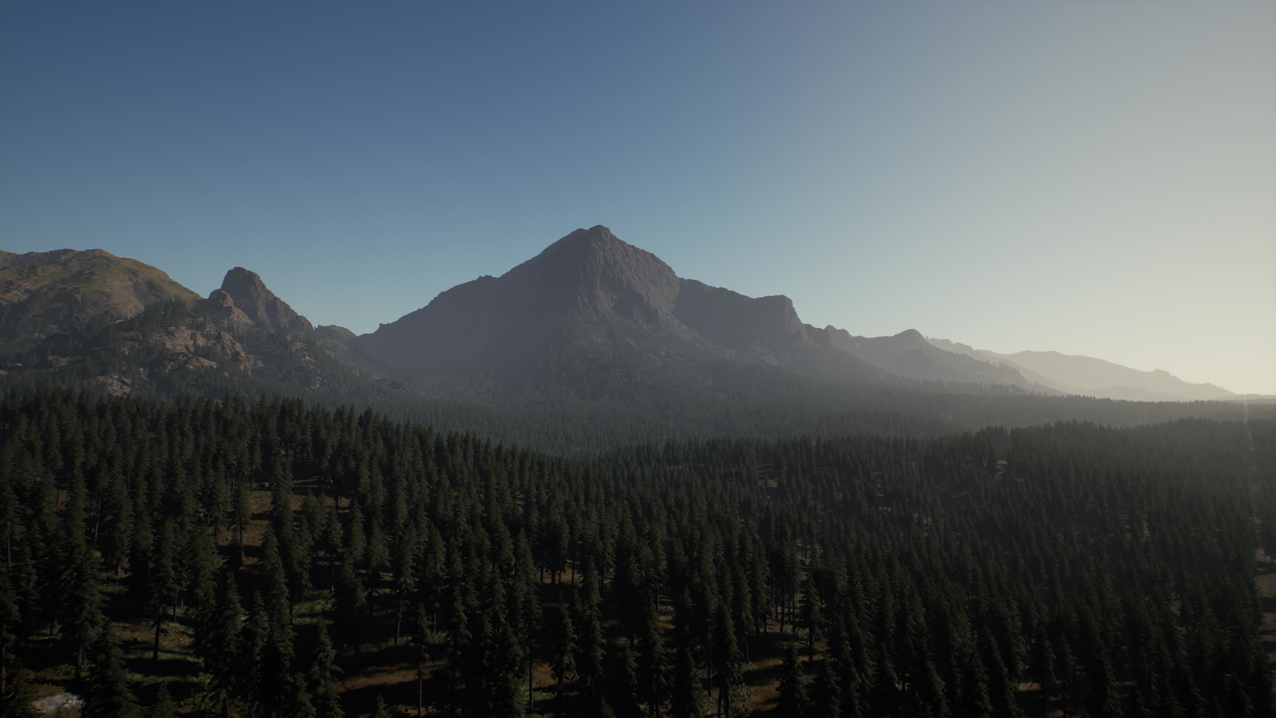 An aerial view of a mountain range with trees in the foreground ...