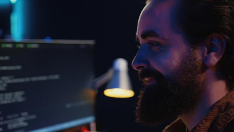 Joyous remotely working programmer in home office doing coding on ...