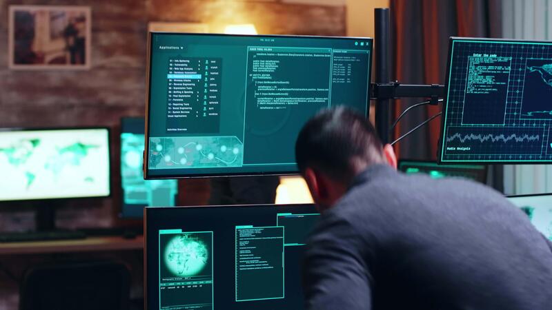 Dangerous hacker watching multiple monitors while working. Cyber ...